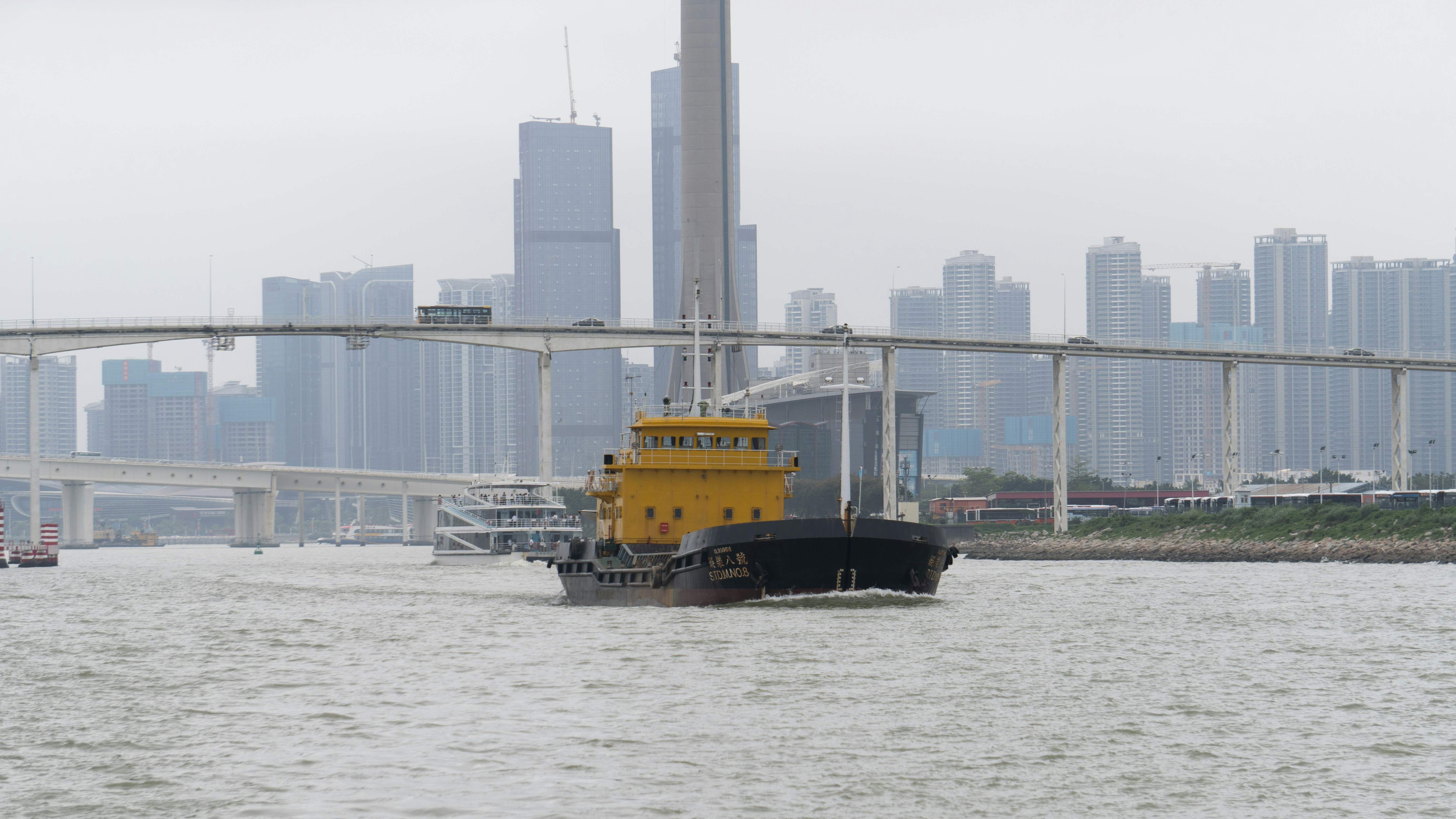 Yellow Tug on a Quiet River beneath a Cityscape