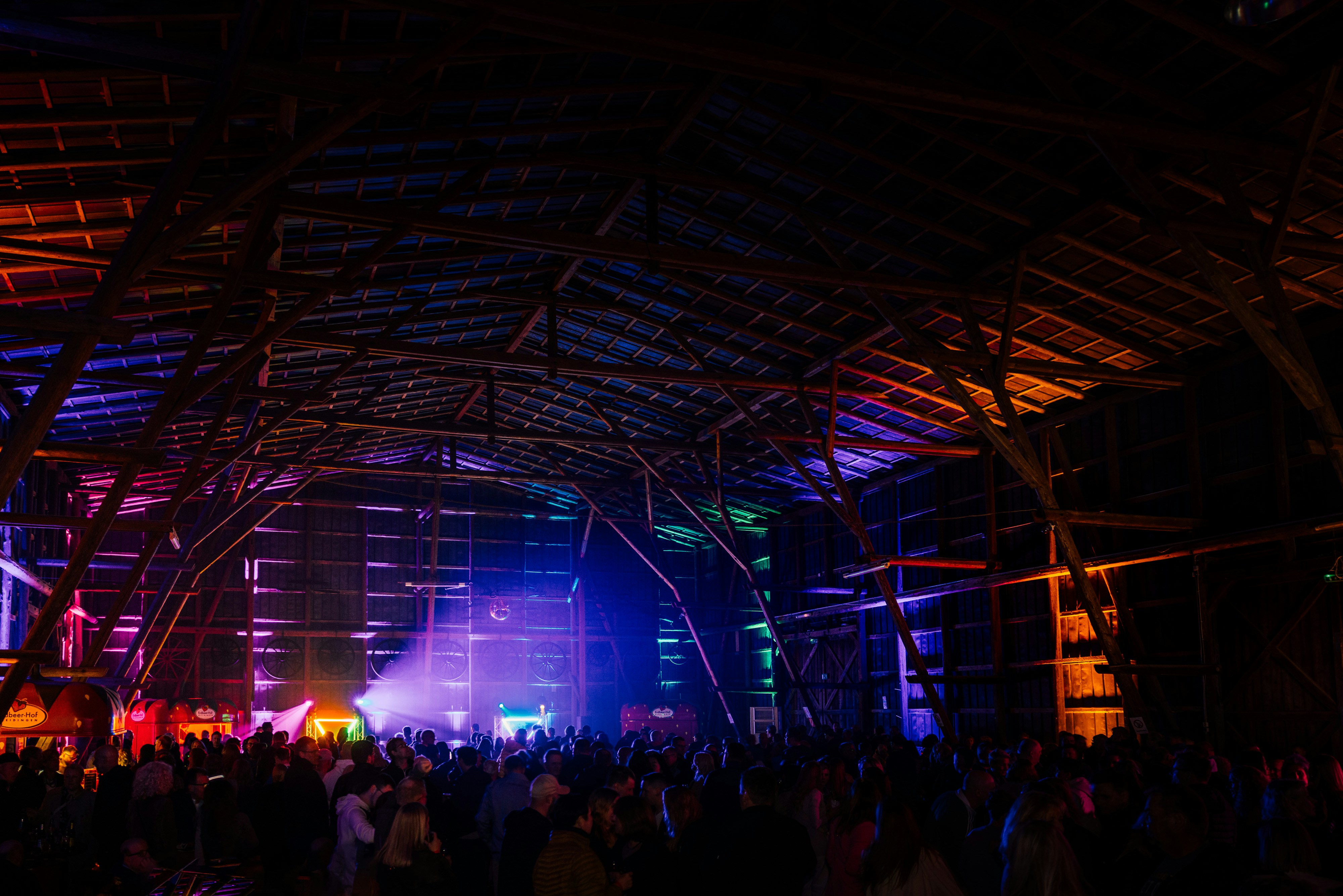 Neon-lit crowd inside a warehouse venue