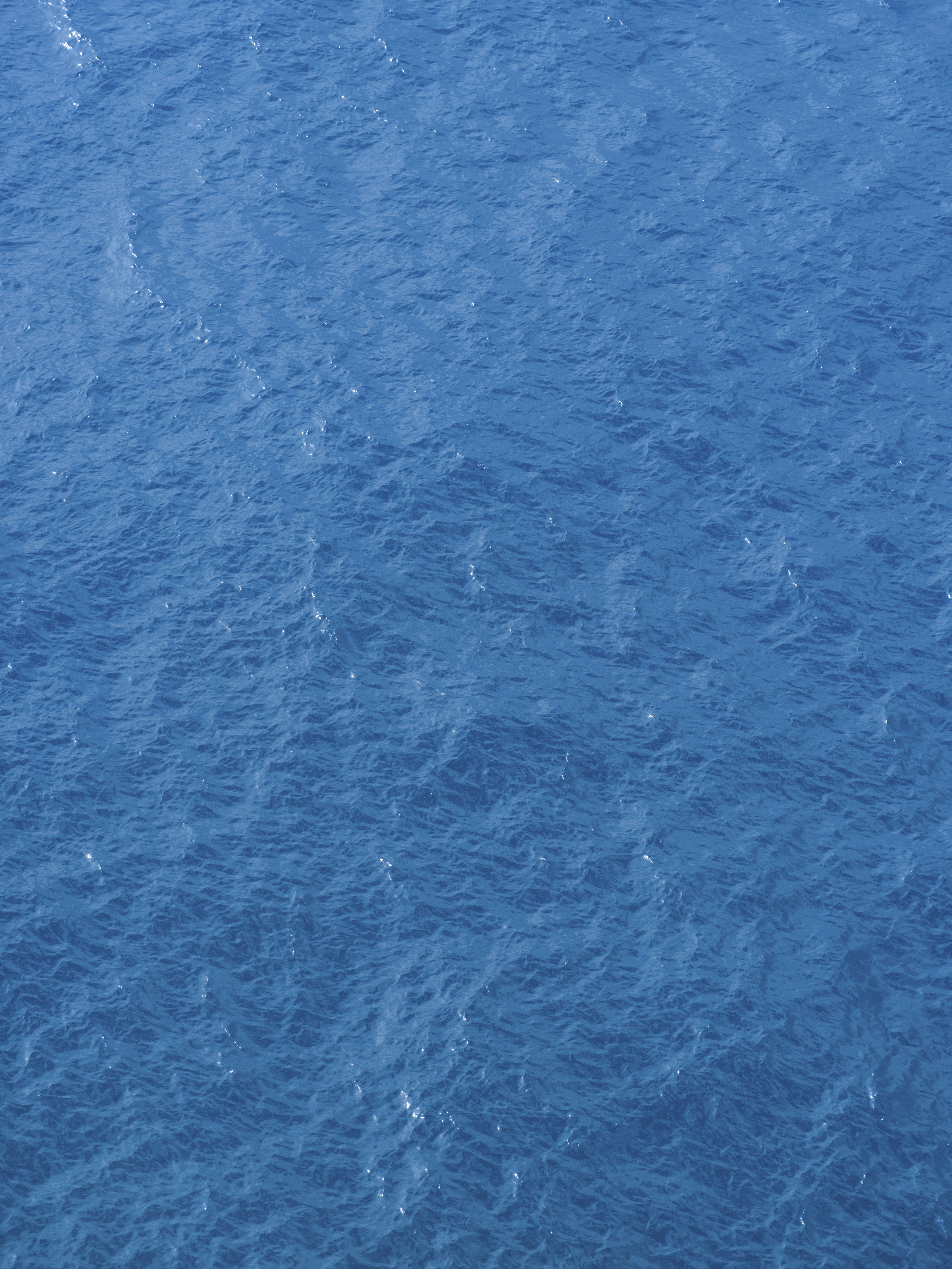 Blue Ripple Mosaic: Sunlit Swells Across an Azure Surface