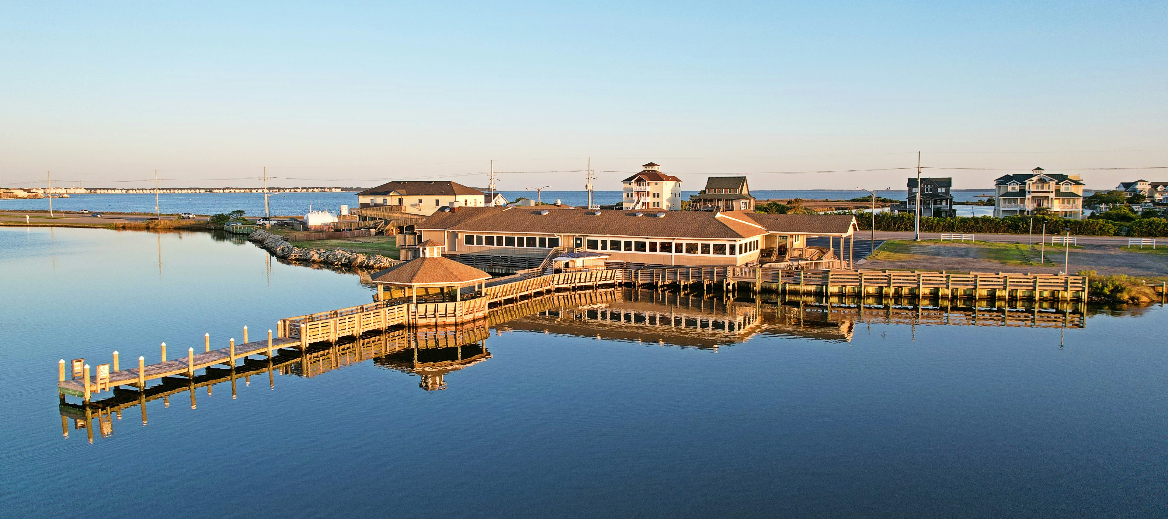 A large body of water next to a pier photo – Free Nags head Image on ...