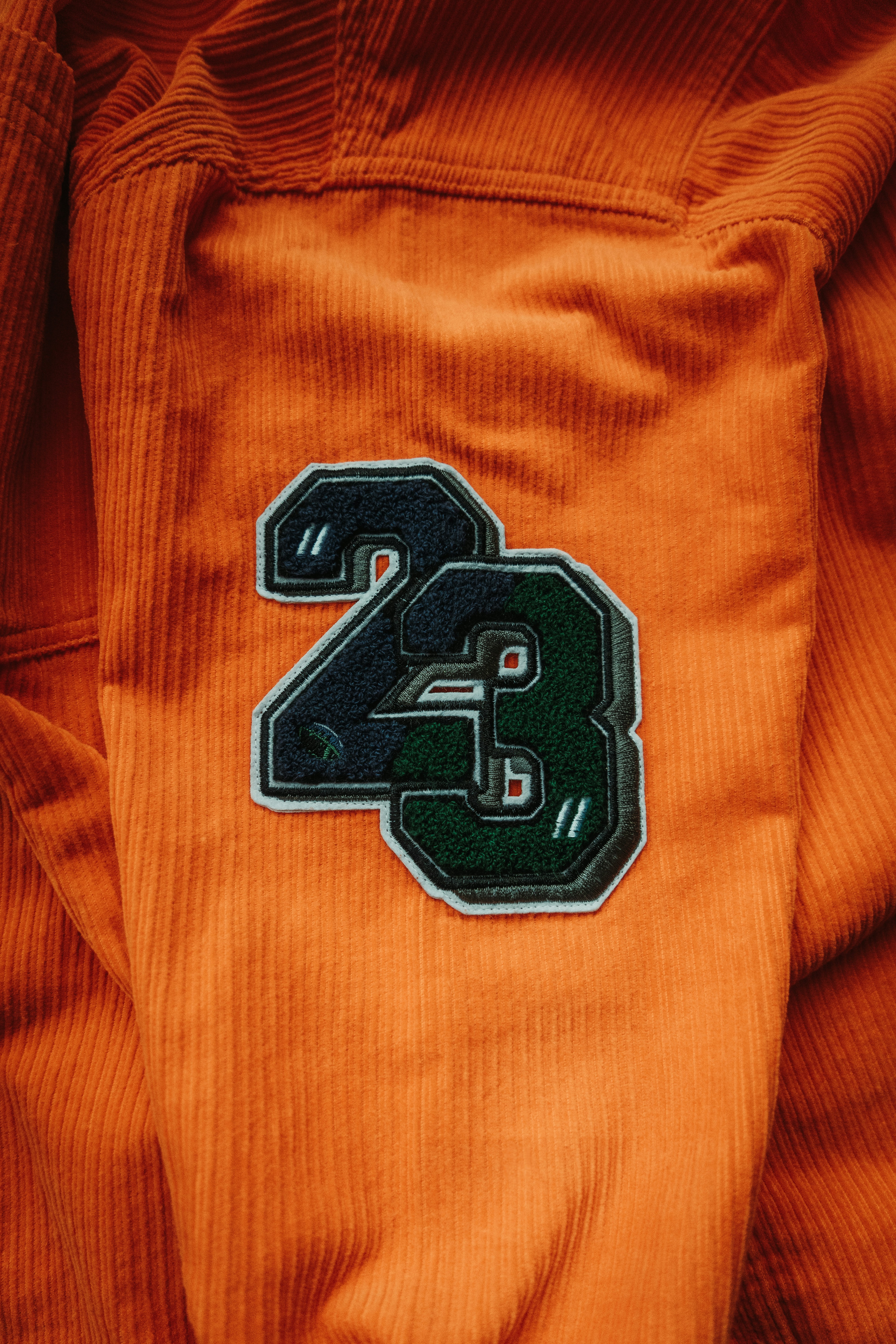 Corduroy Spotlight: Embroidered 23 Patch on Orange Fabric