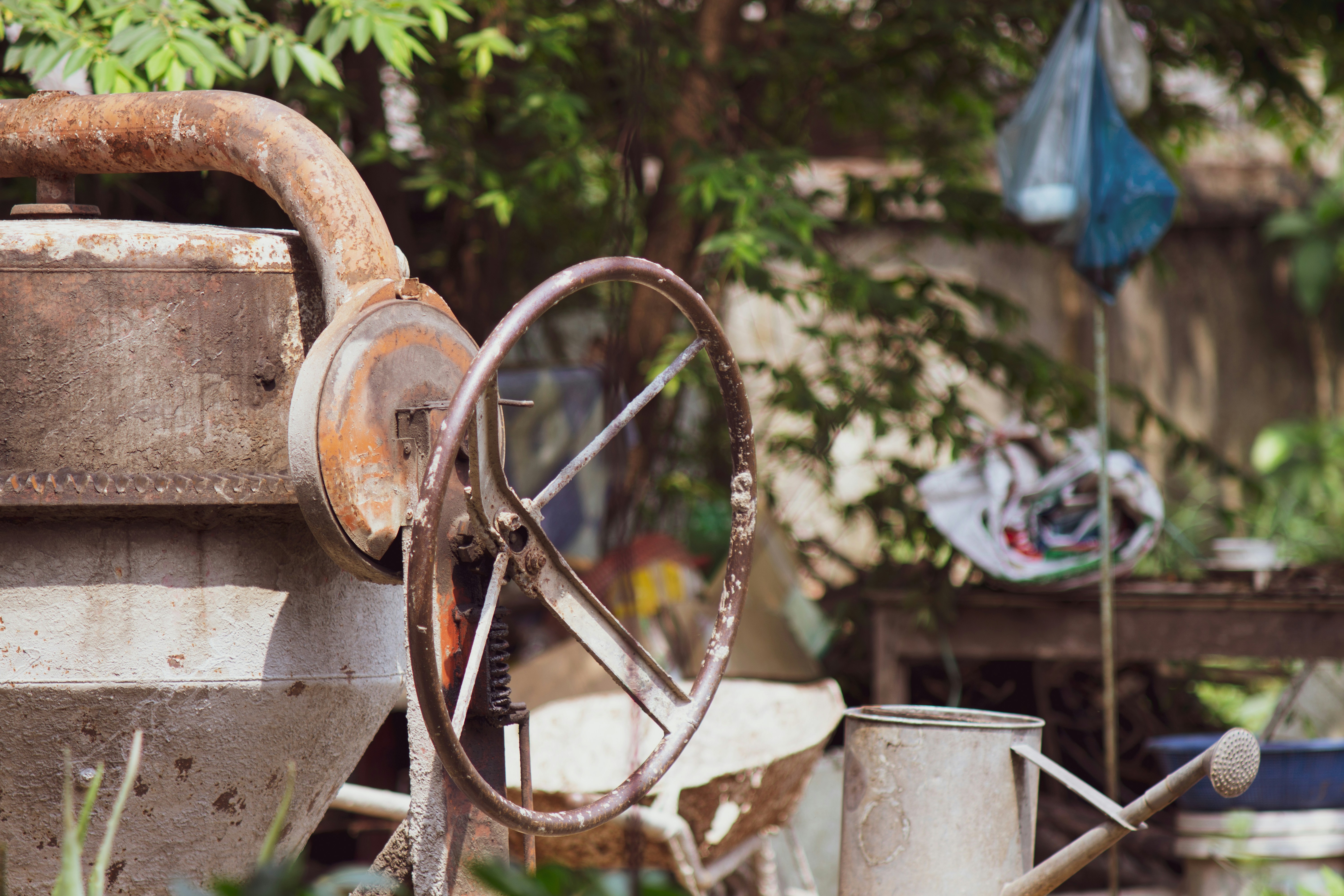 A rusted out watering can with a spigot next to it photo – Free Machine ...