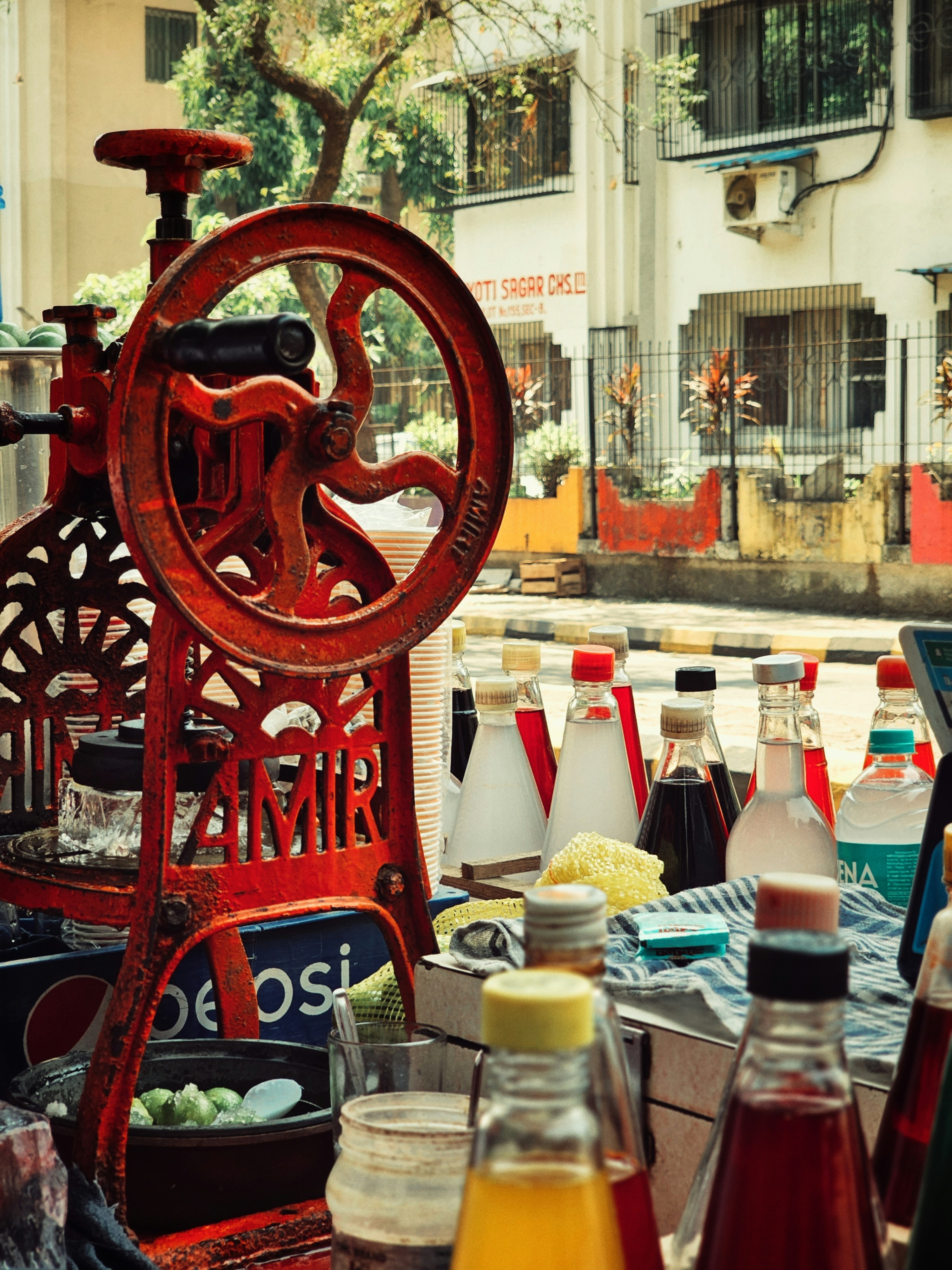 Red Cast of Flavor: A Vintage Soda Setup Framed by a Steam Press