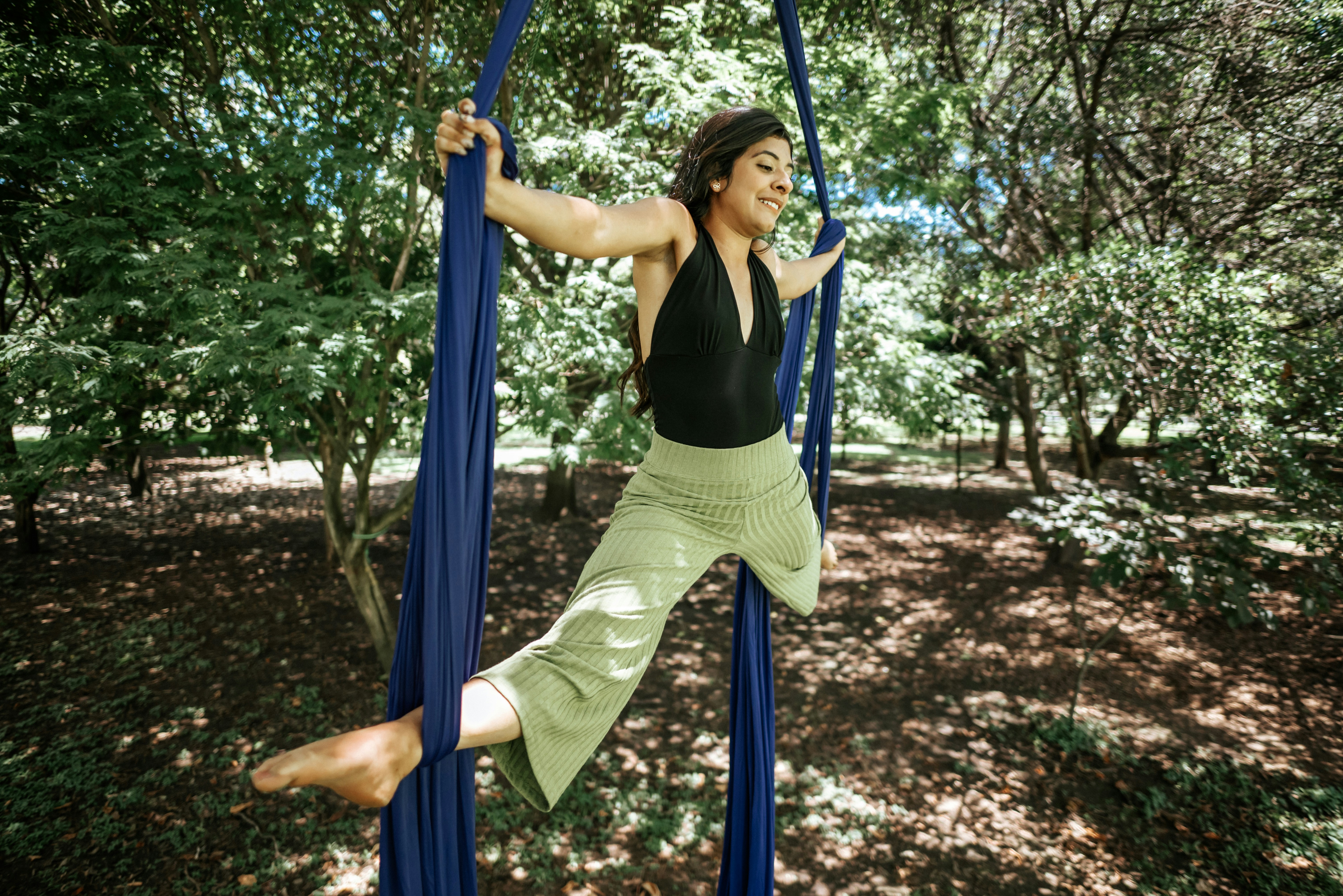 Aerial Grace in the Park: Silk Dancer Between Blue Ribbons