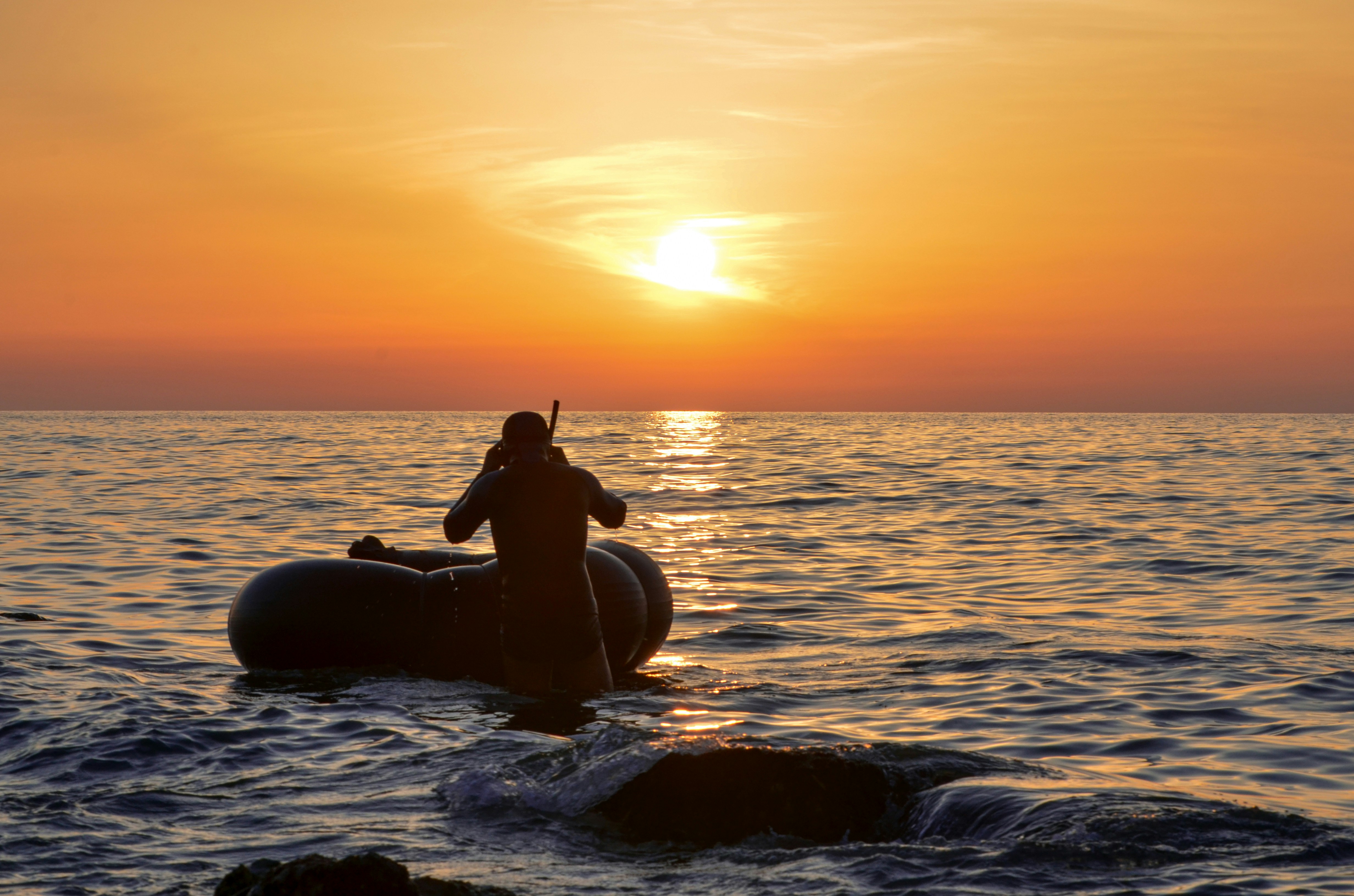 A person on a raft in the ocean at sunset photo – Free Sun at sunset ...