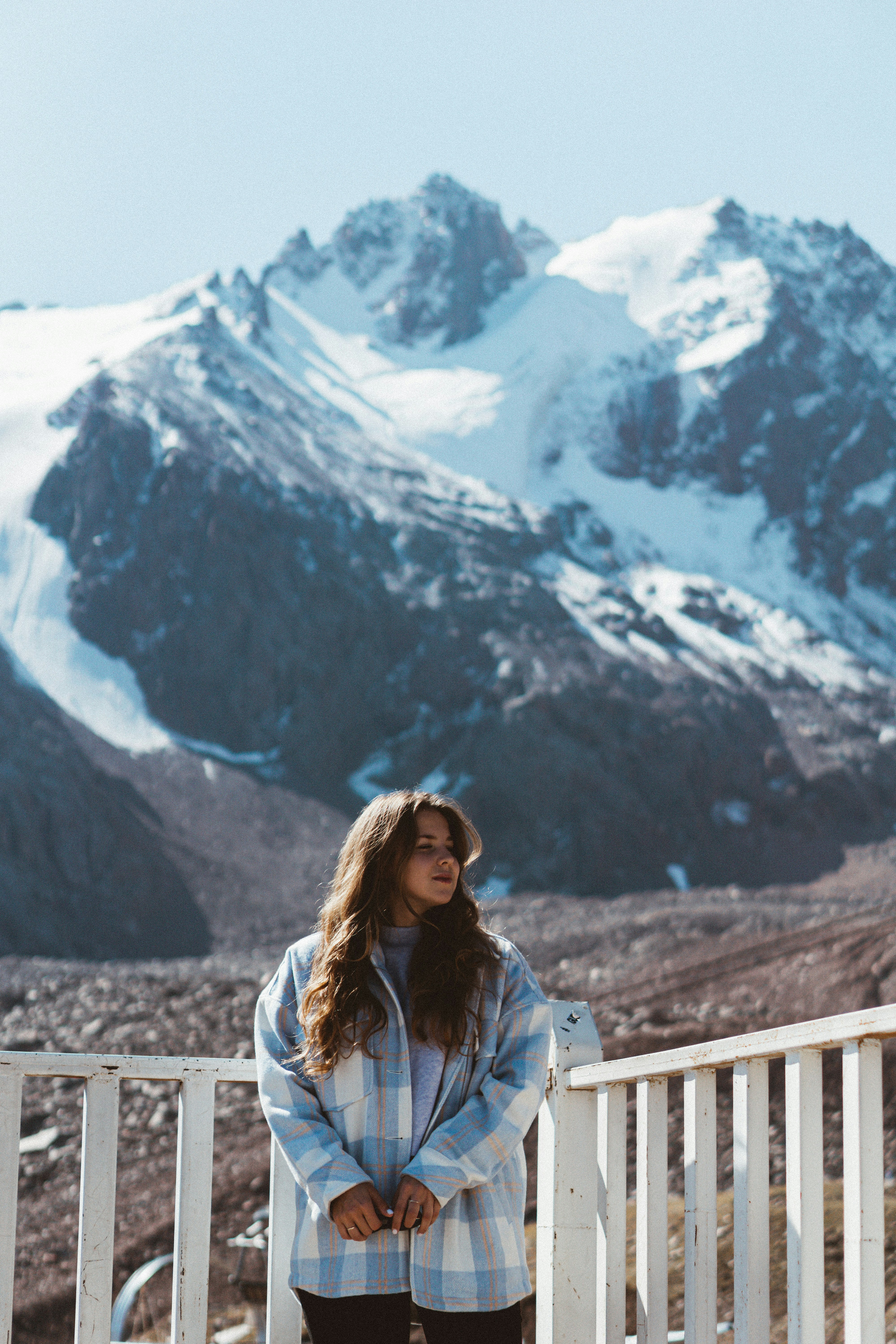 Glacial Quietude: A Woman in a Powder-Blue Plaid Coat at the Mountain Balcony