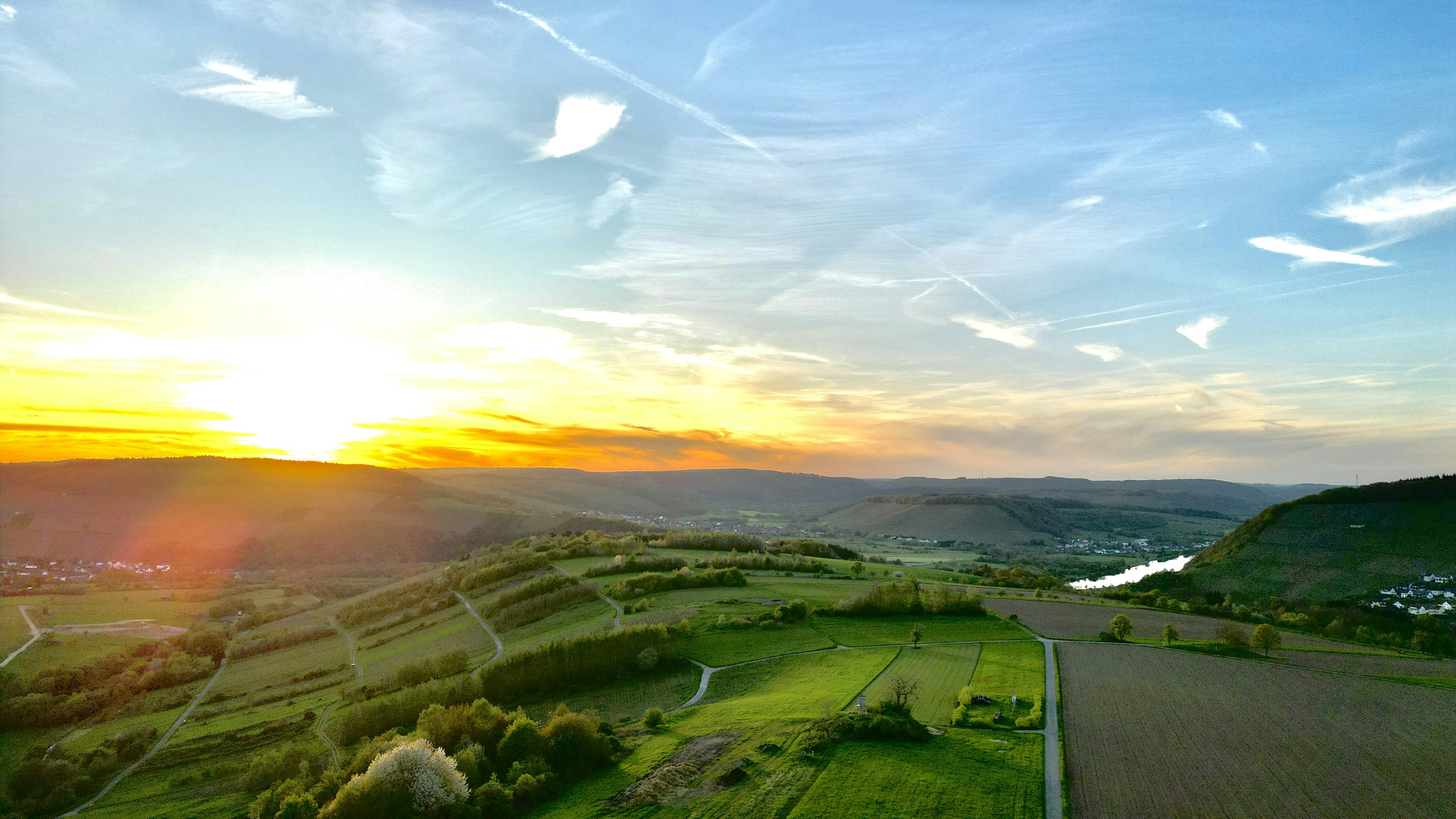 Terraced Valleys at Sunset: Golden Veil Over Rolling Farmlands