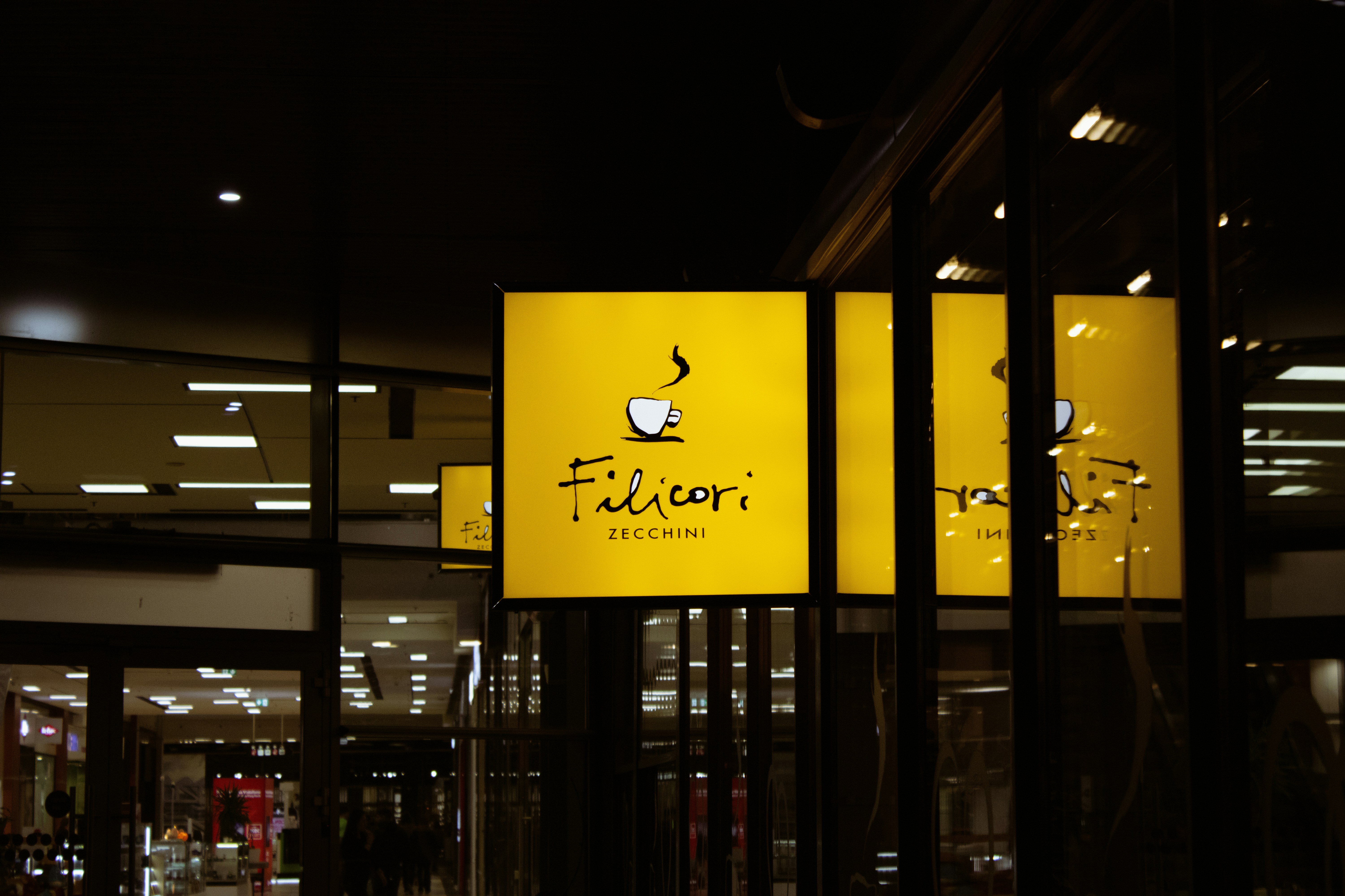 Night Signage Through Glass: A Yellow Café Brand Illuminates a Quiet Shopfront