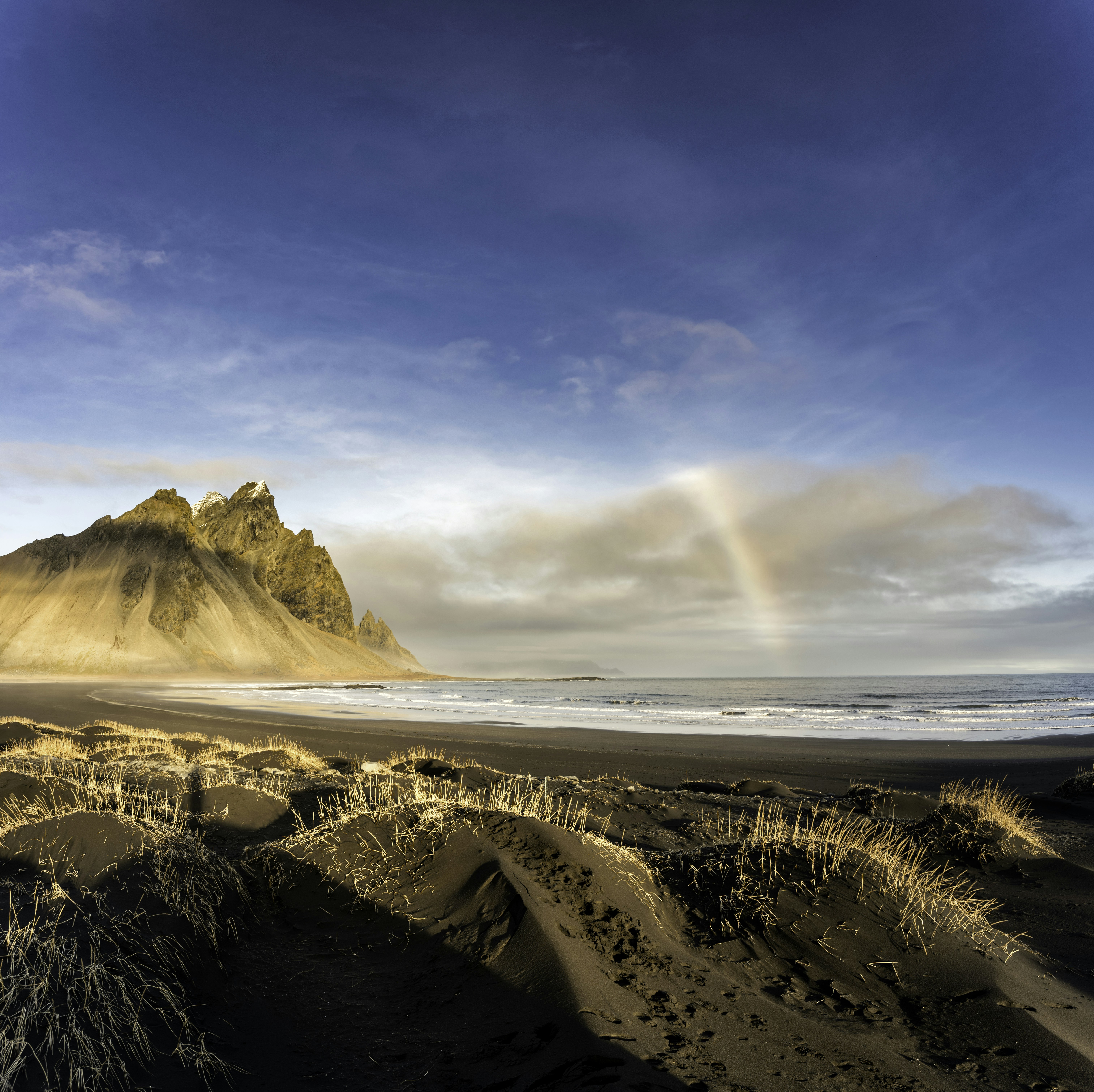 A beach with sand dunes and a mountain in the background photo – Free ...