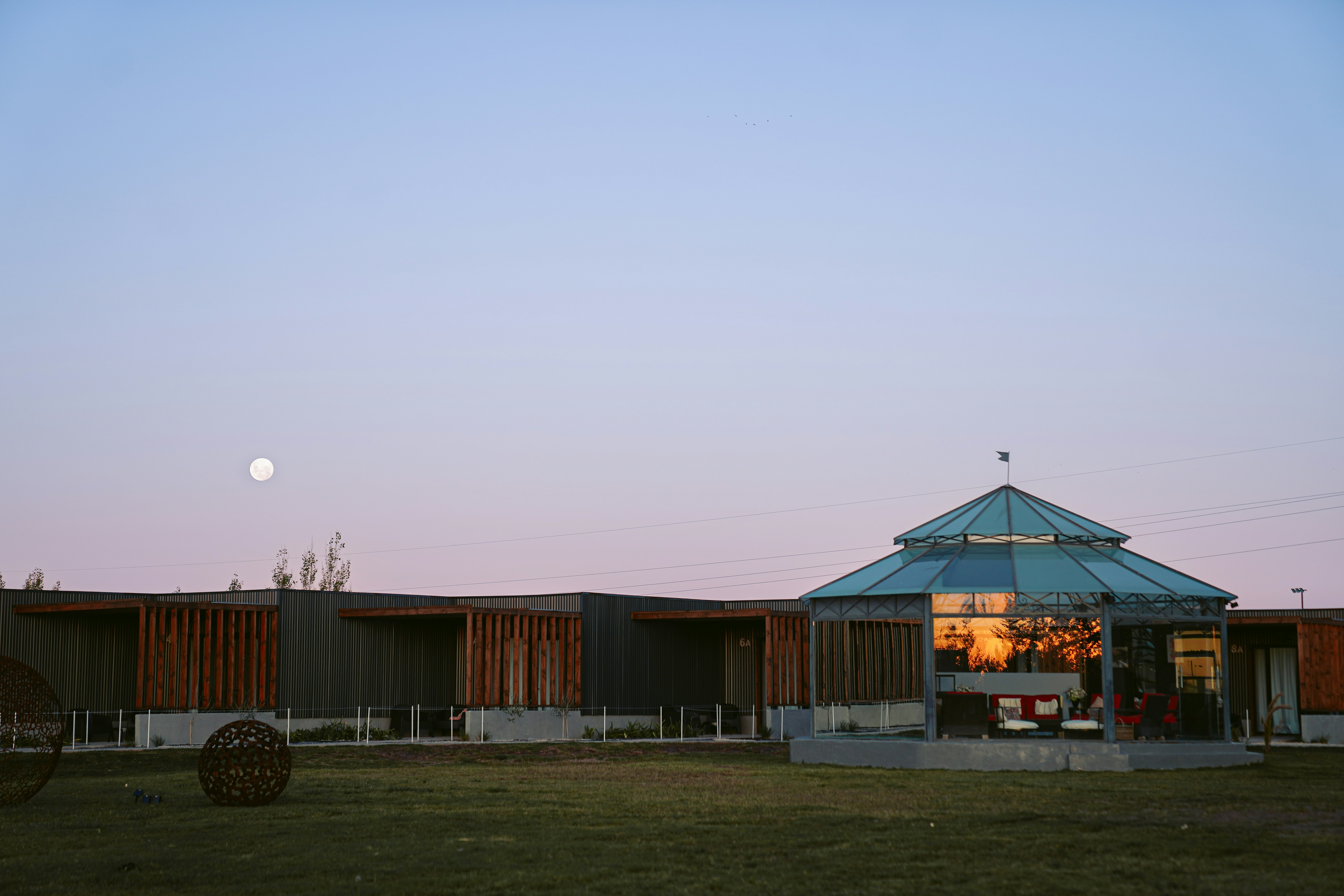 a building with a blue roof and a full moon in the sky