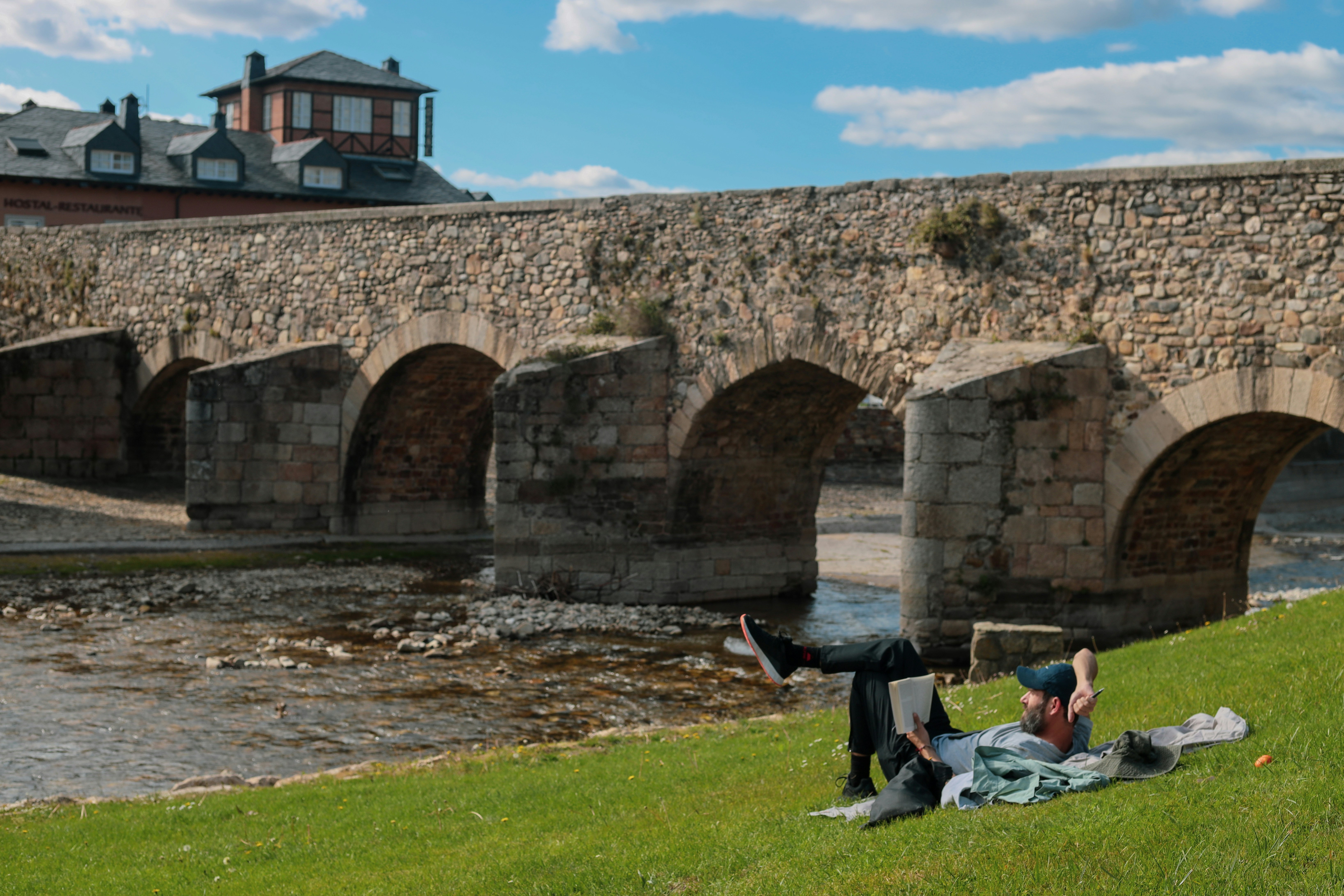 Picnic by the Arched Bridge: Quiet Riverbank in Afternoon Light