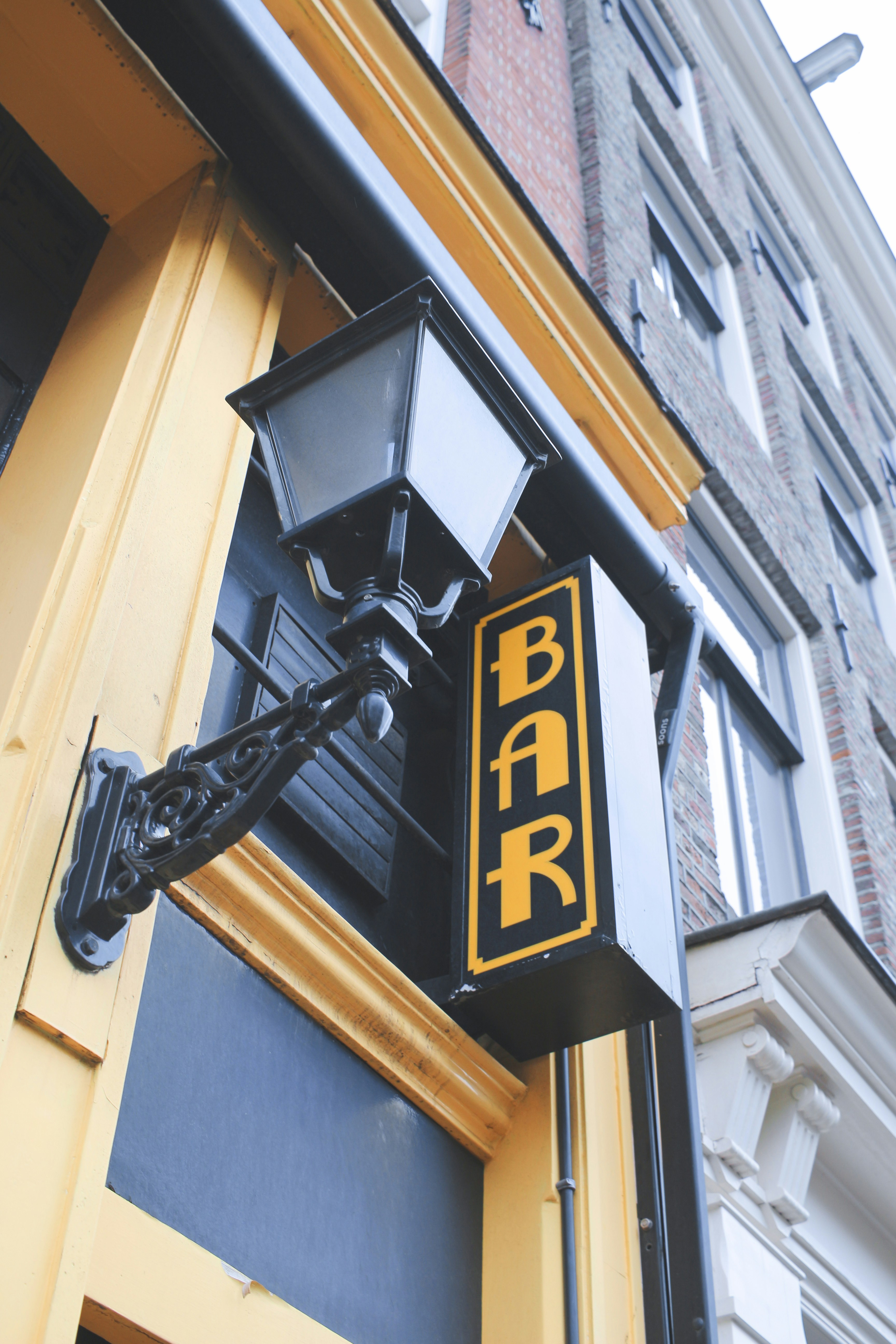 Lanterned Barsign Adrift on a Lively City Façade