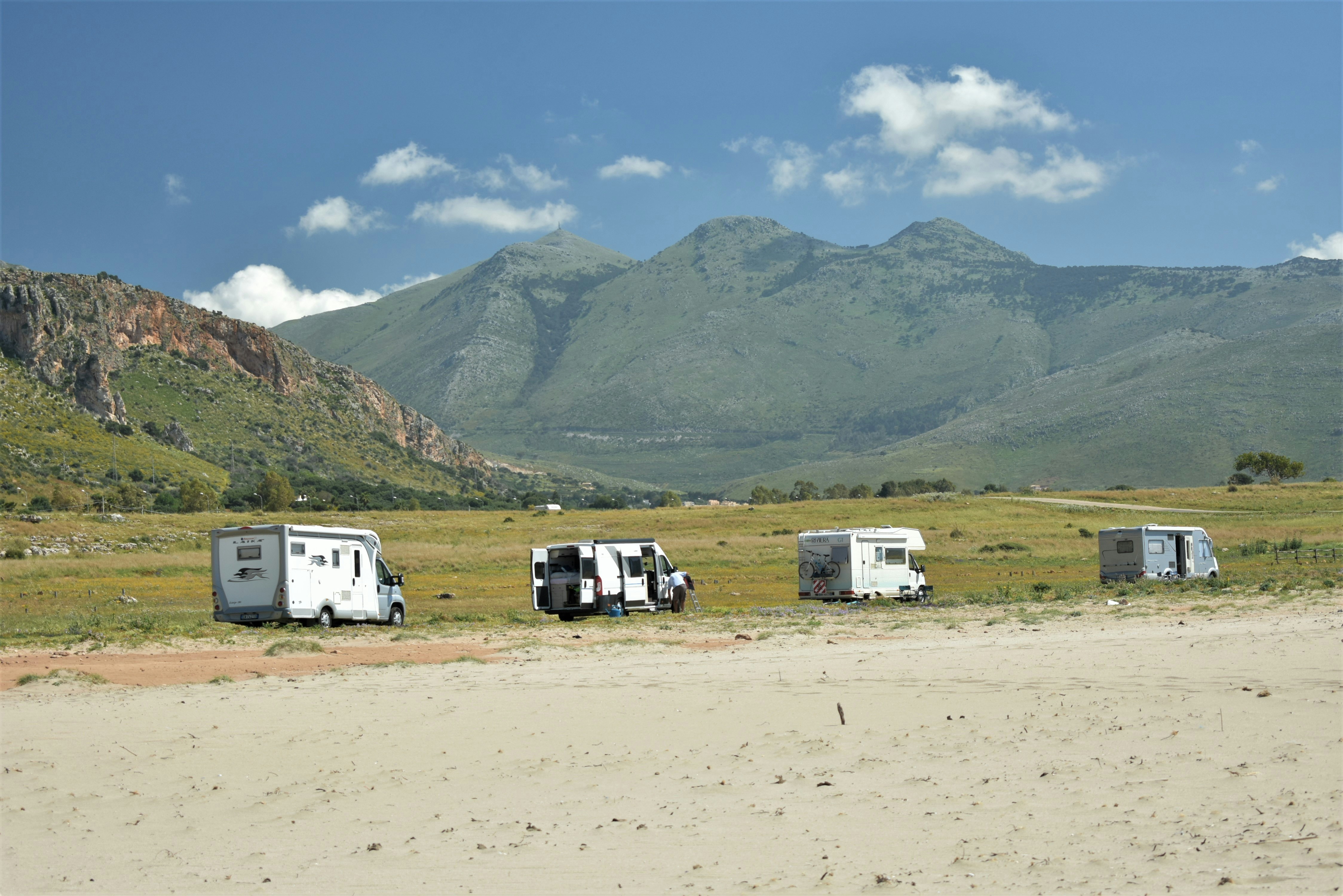 A group of four travel trailers parked in a field photo – Free Macari ...