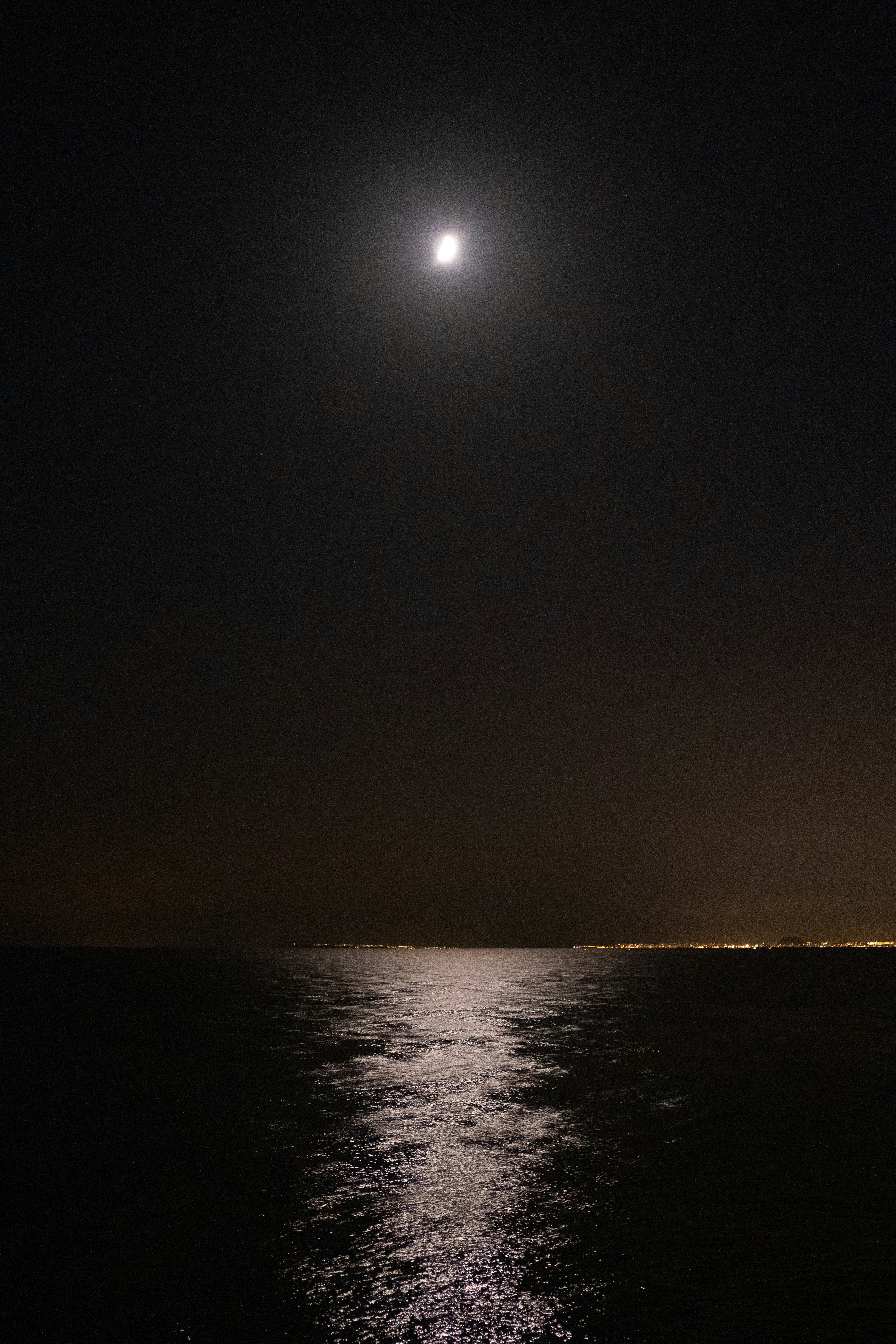 A full moon is seen over the ocean at night photo – Free Night Image on ...