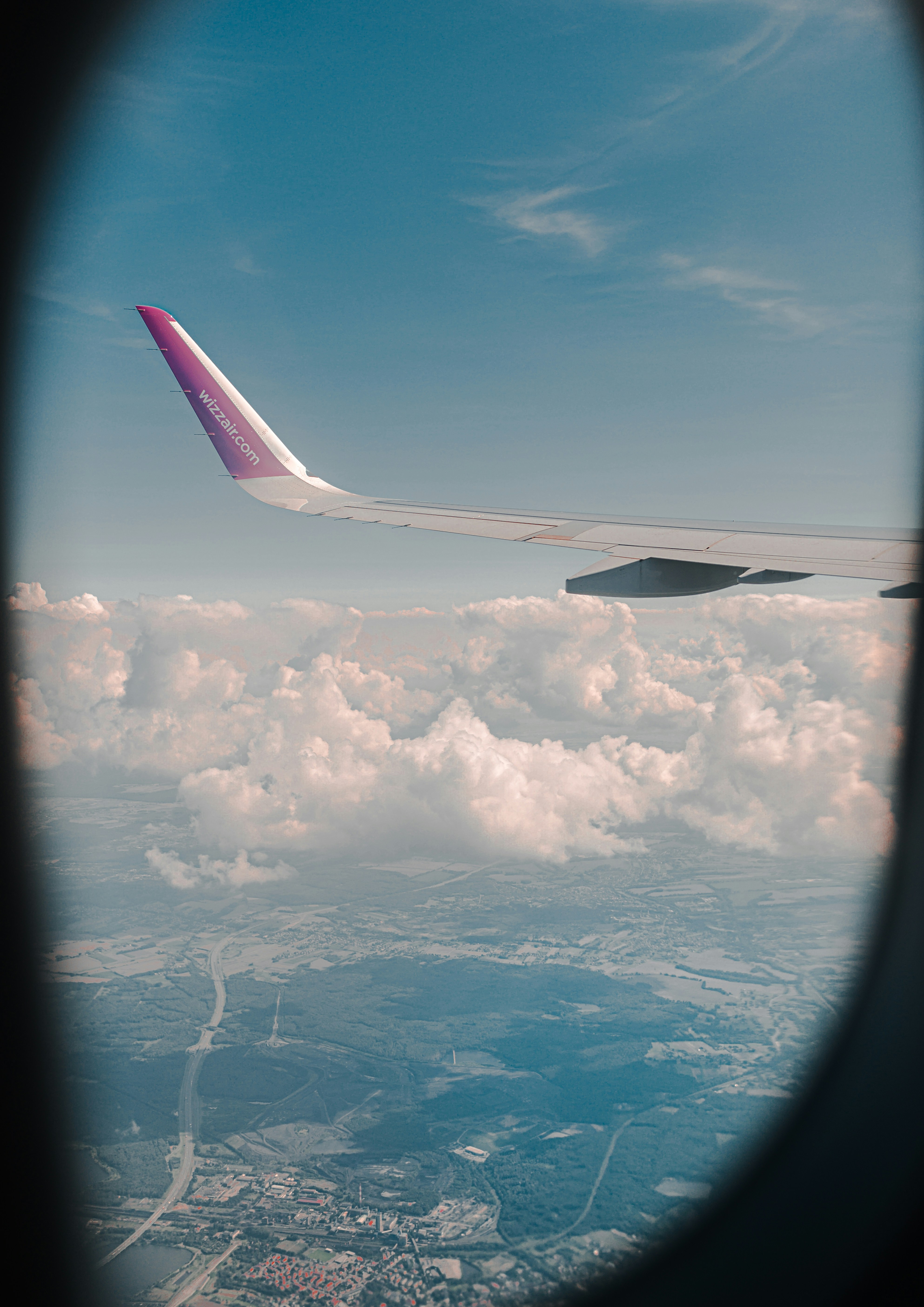Purple Winglet Above a Sea of Clouds: Window-Seat Perspective