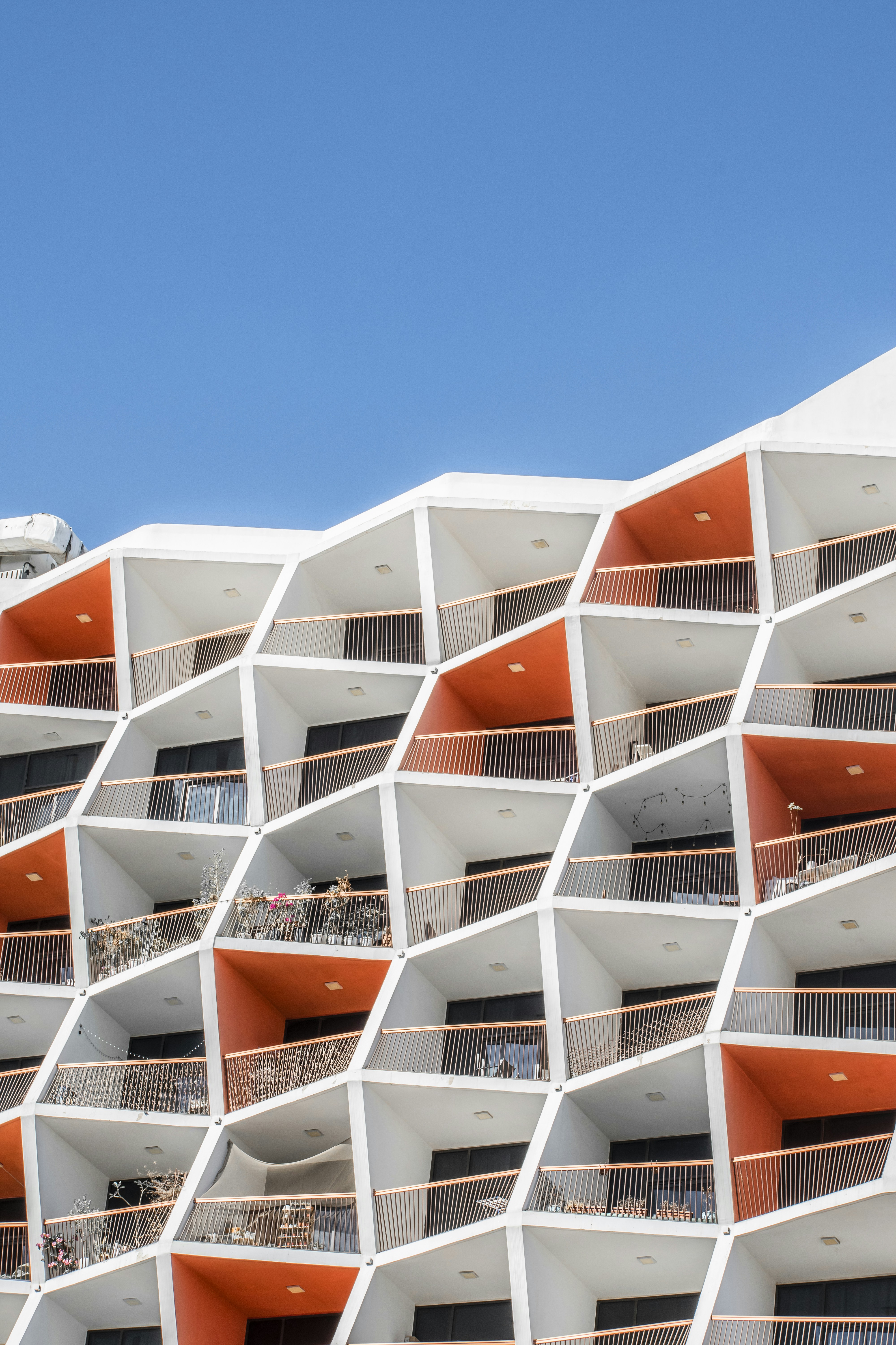 A building with orange and white balconies and balconies photo – Free ...