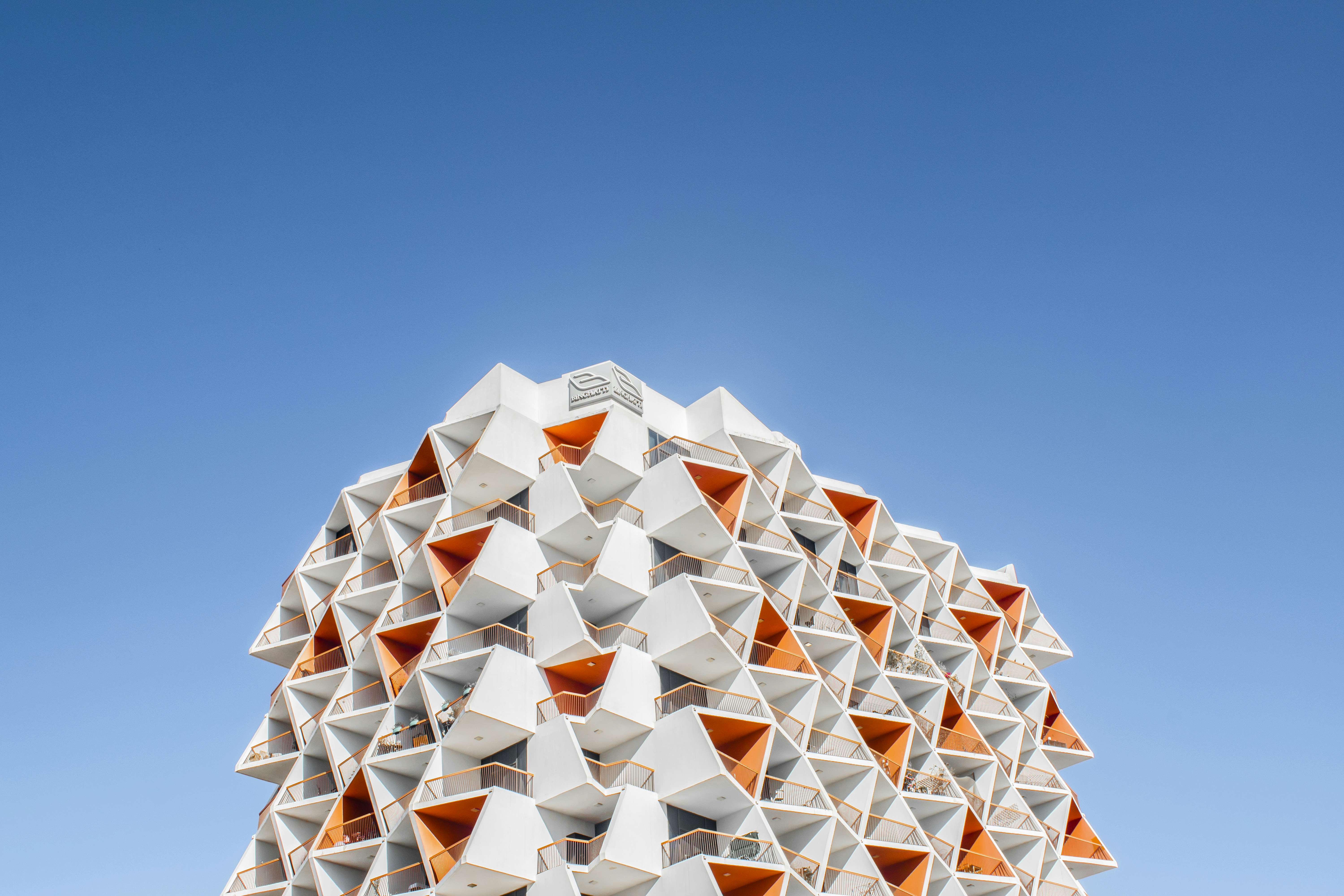 A tall white building with orange triangles on it photo – Free Dubai ...