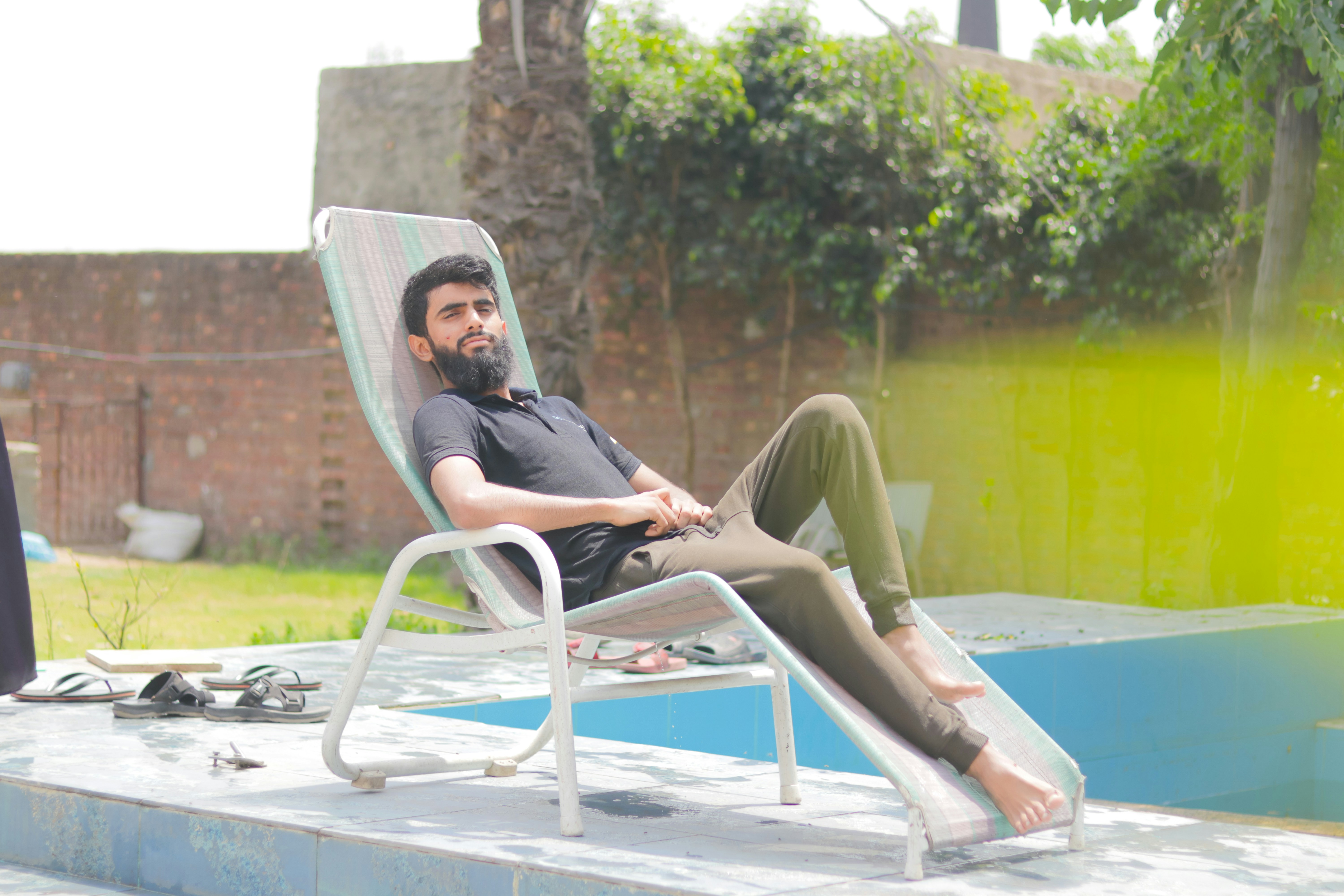 Relaxed by the Pool: A Man Unwinds in a Curved Lounge