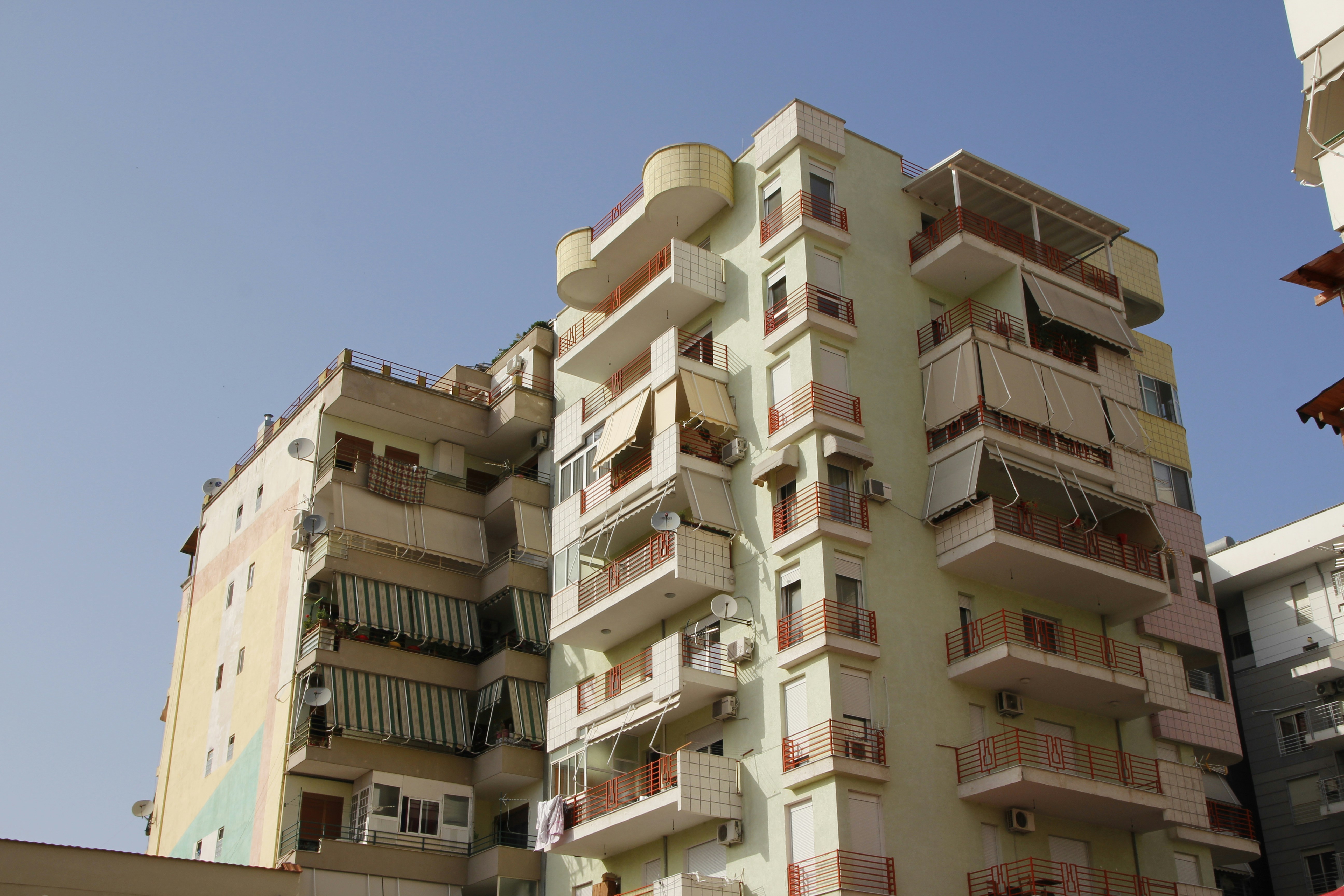 Foto Un edificio alto con balcones y balcones en los balcones – Imagen Albania gratis en Unsplash