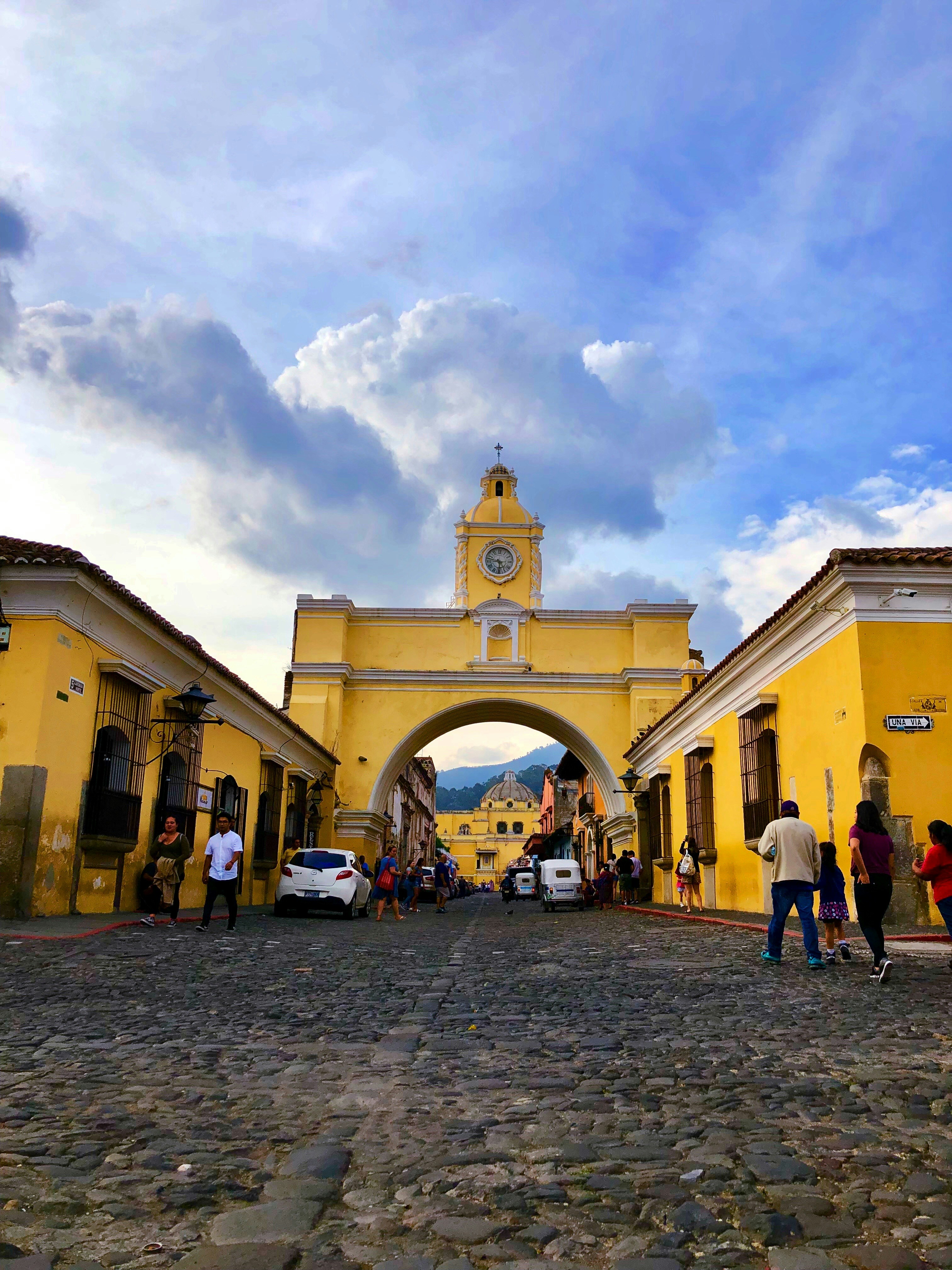 Antigua Guatemala. Arco de Santa Catalina | a group of people standing in front of a yellow building