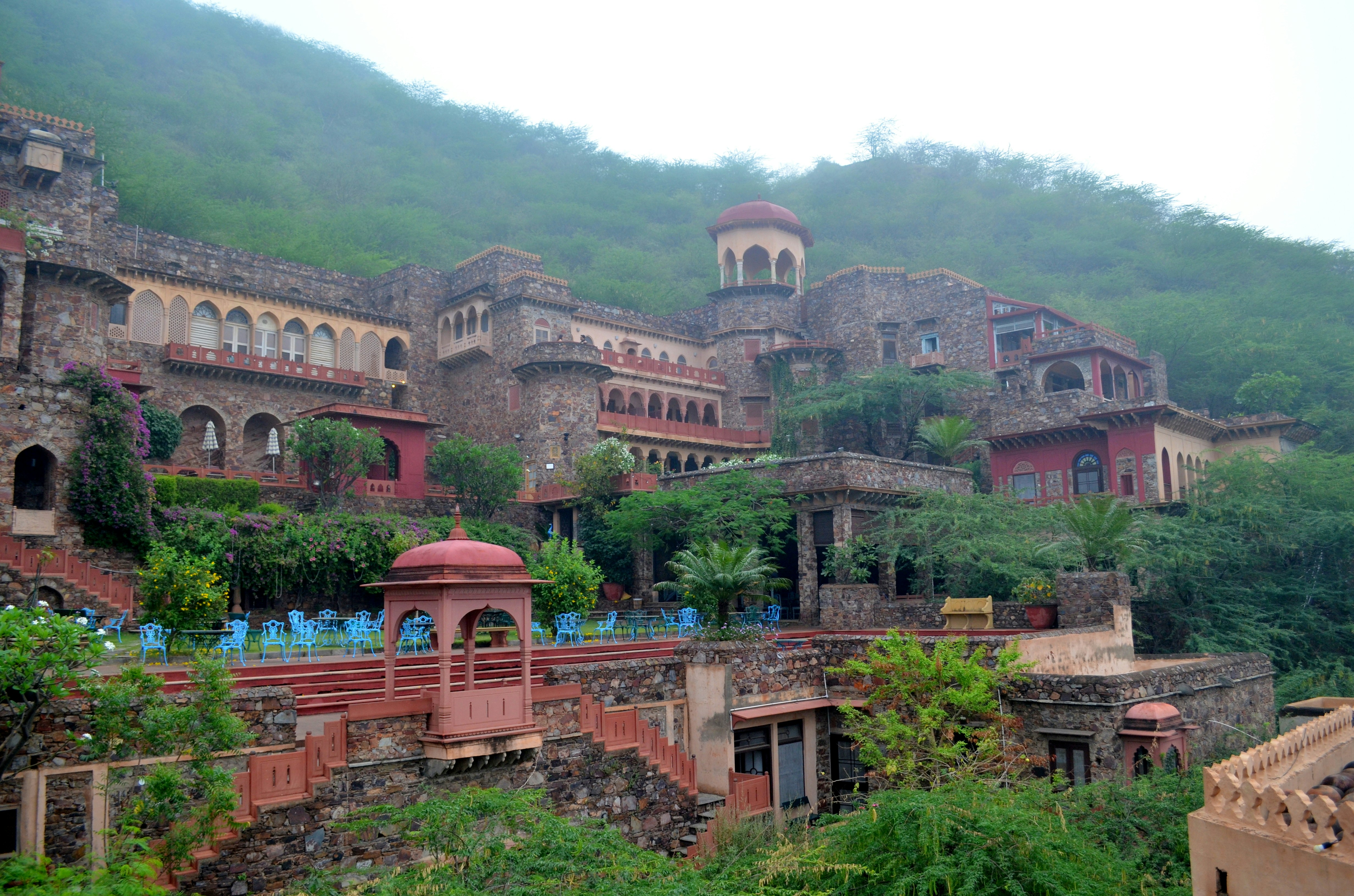 Fortress on the Hillside: Terraced Architecture Weaving Through Green Mist