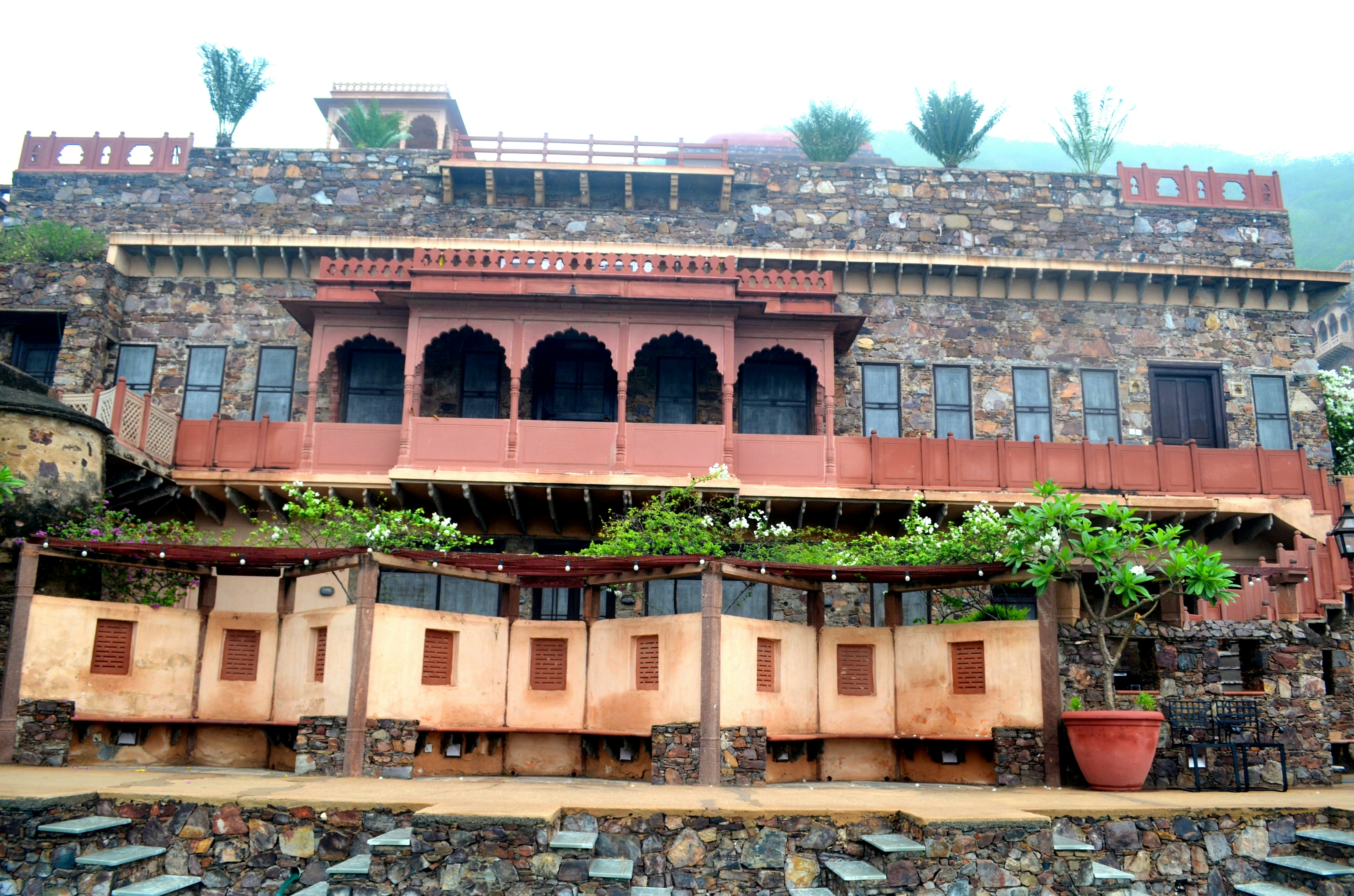 Terracotta Arches Crown a Weathered Stone Villa on a Terraced Slope