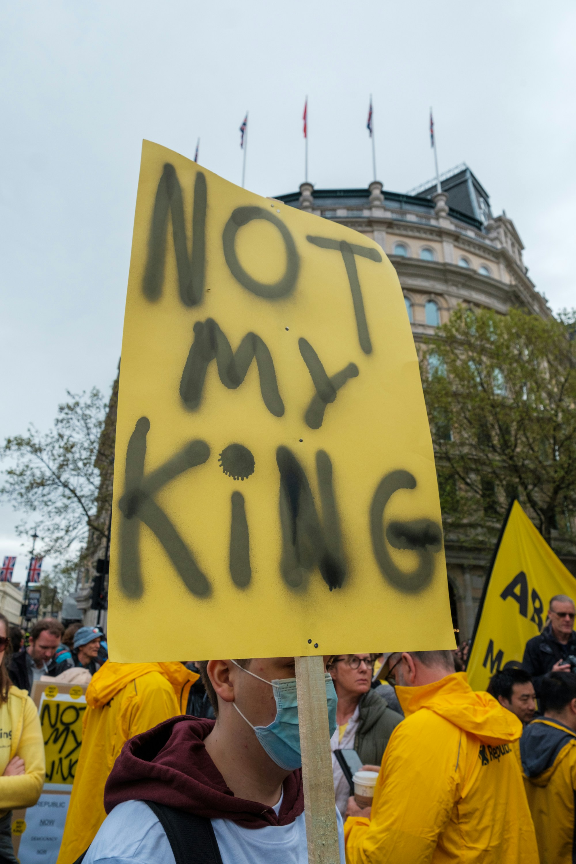 A group of people holding a sign that says not my king photo – Free ...