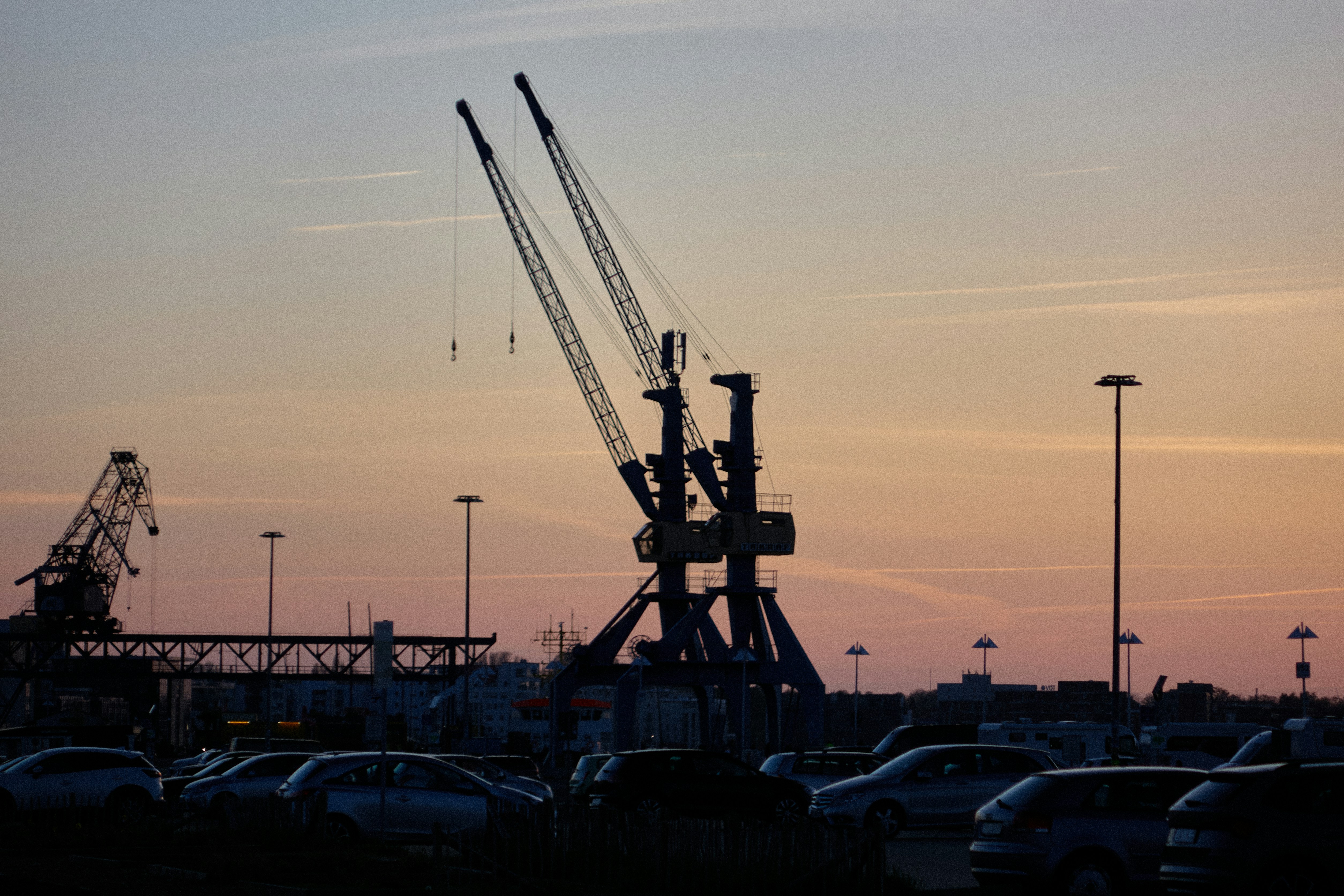Sunset Silhouettes: Harbor Cranes Framing a Quiet Parking Lot