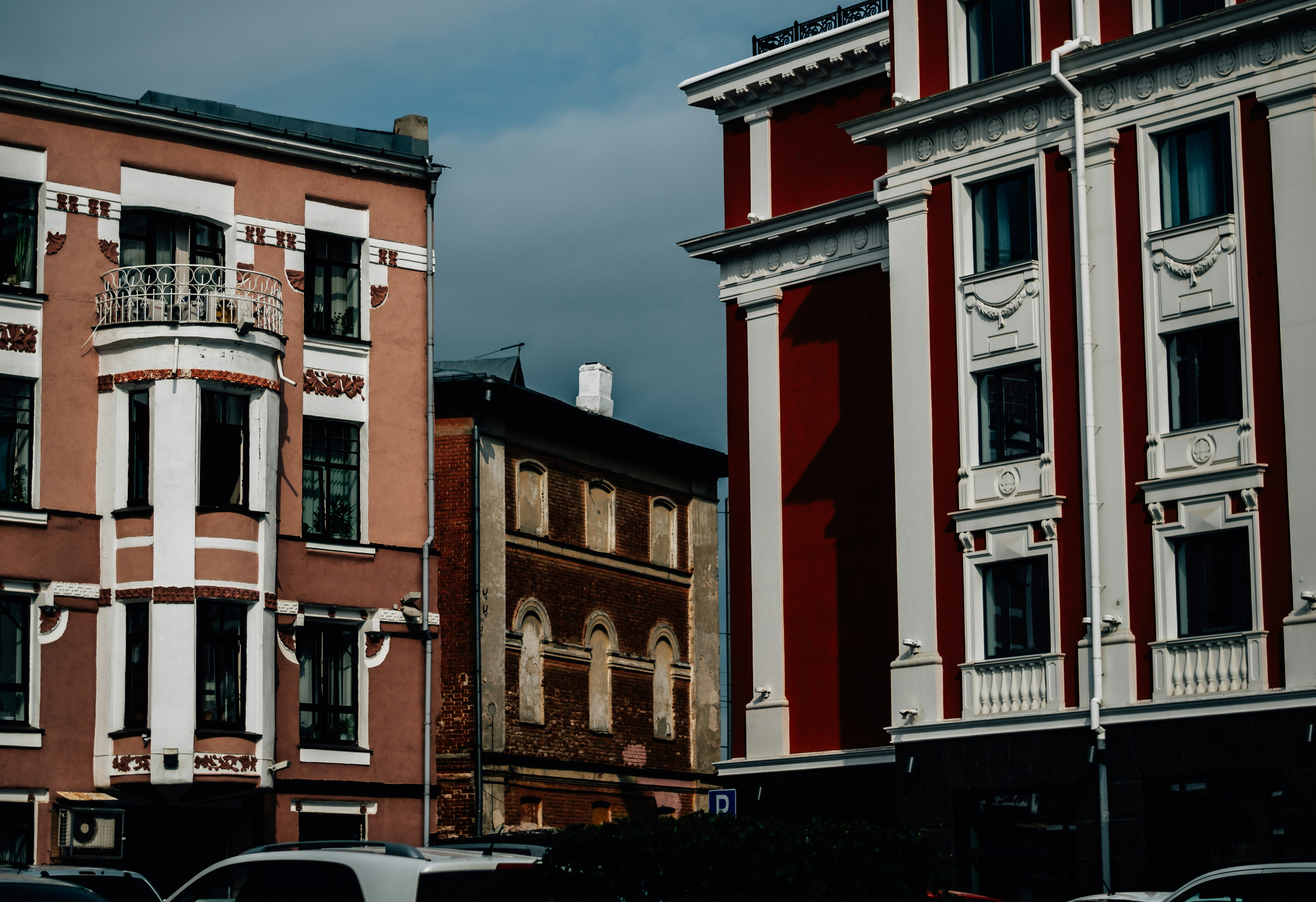 Historic buildings with distinct architectural styles under a cloudy sky.