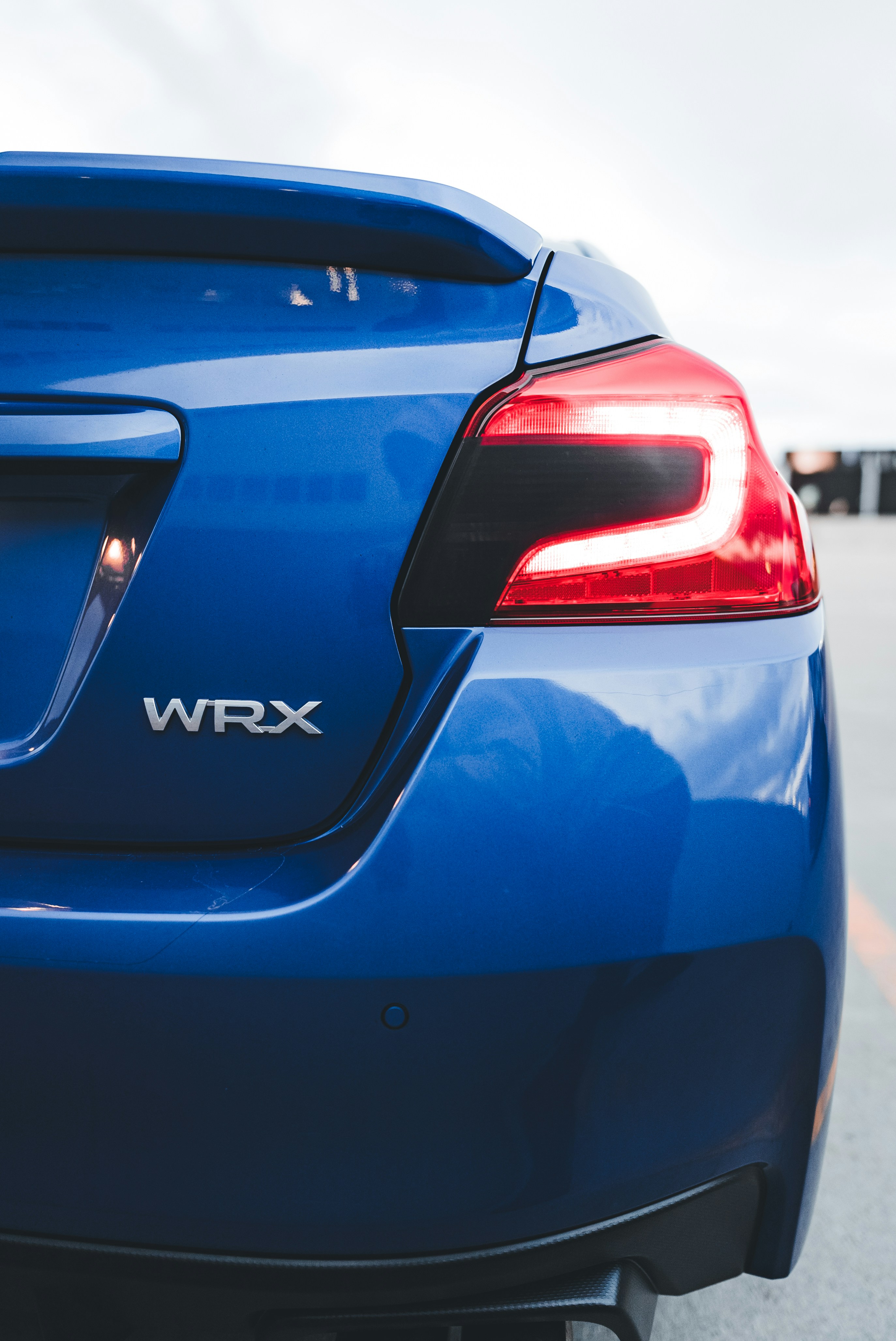 The rear end of a blue car parked in a parking lot photo – Free Bumper ...