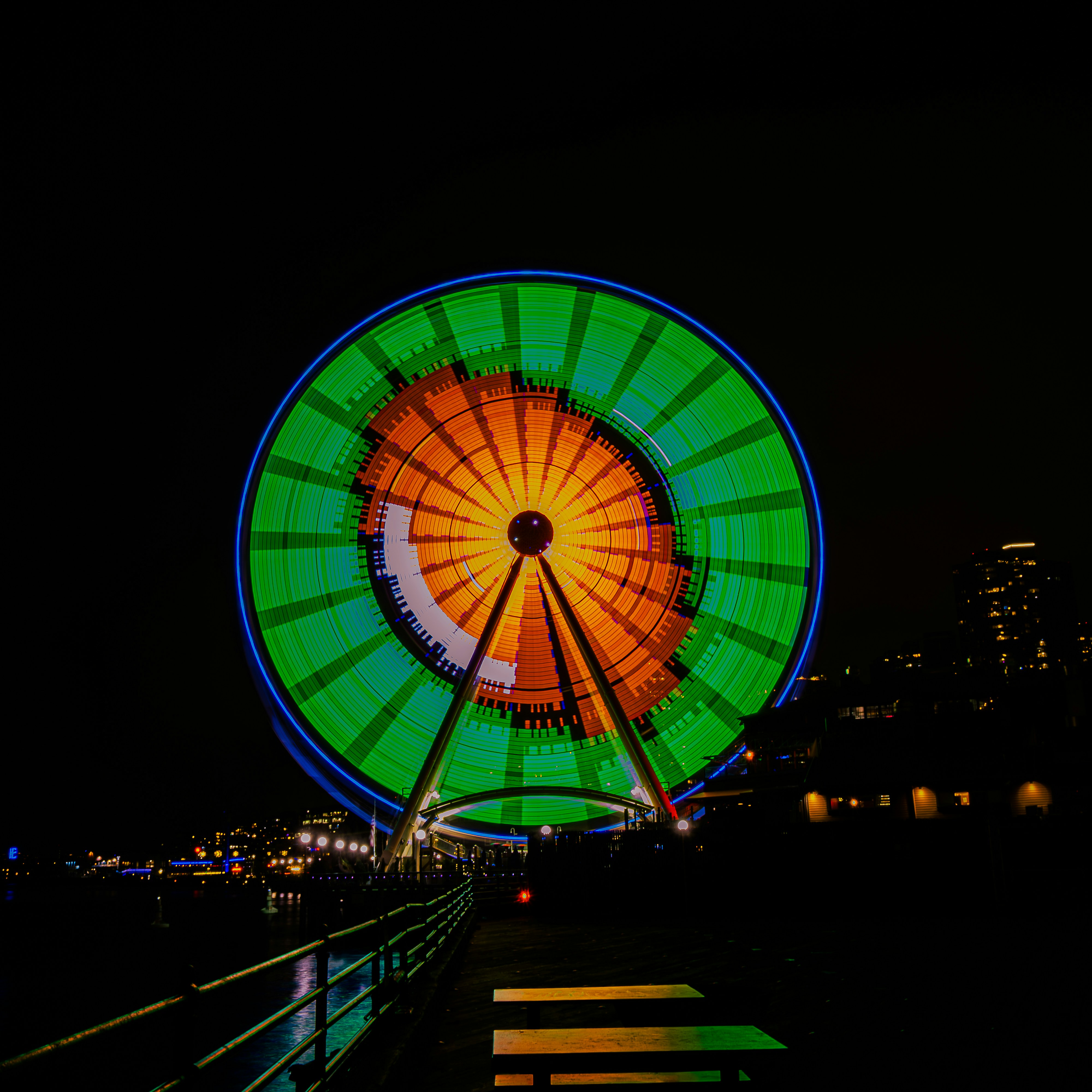 Neon Spokes Over the Pier: Nighttime Ferris Wheel of Color