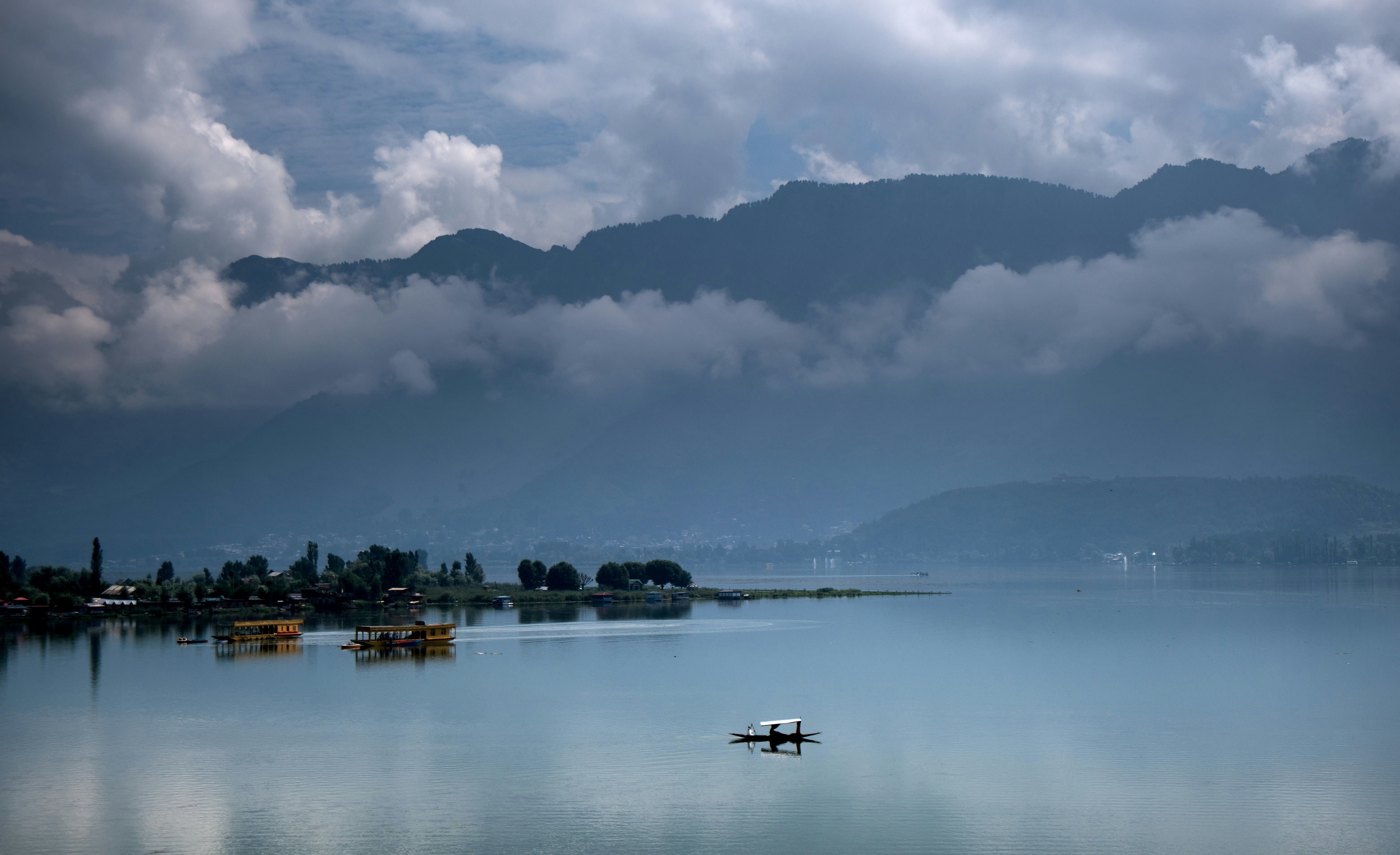 Dal Lake | a person in a boat on a large body of water