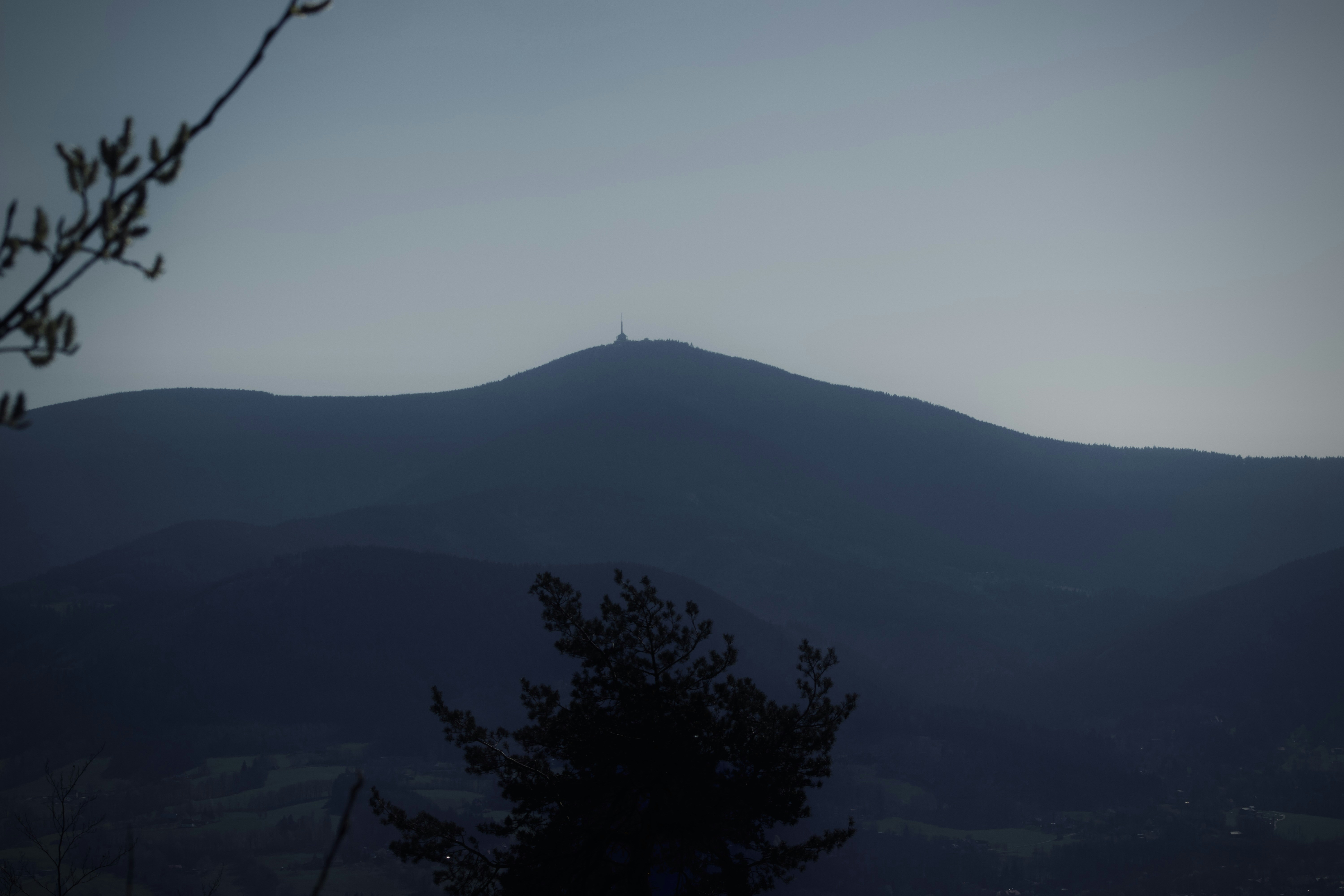 Dusk Crest: The Lone Tower Crowned by Velvet Blue Mountains