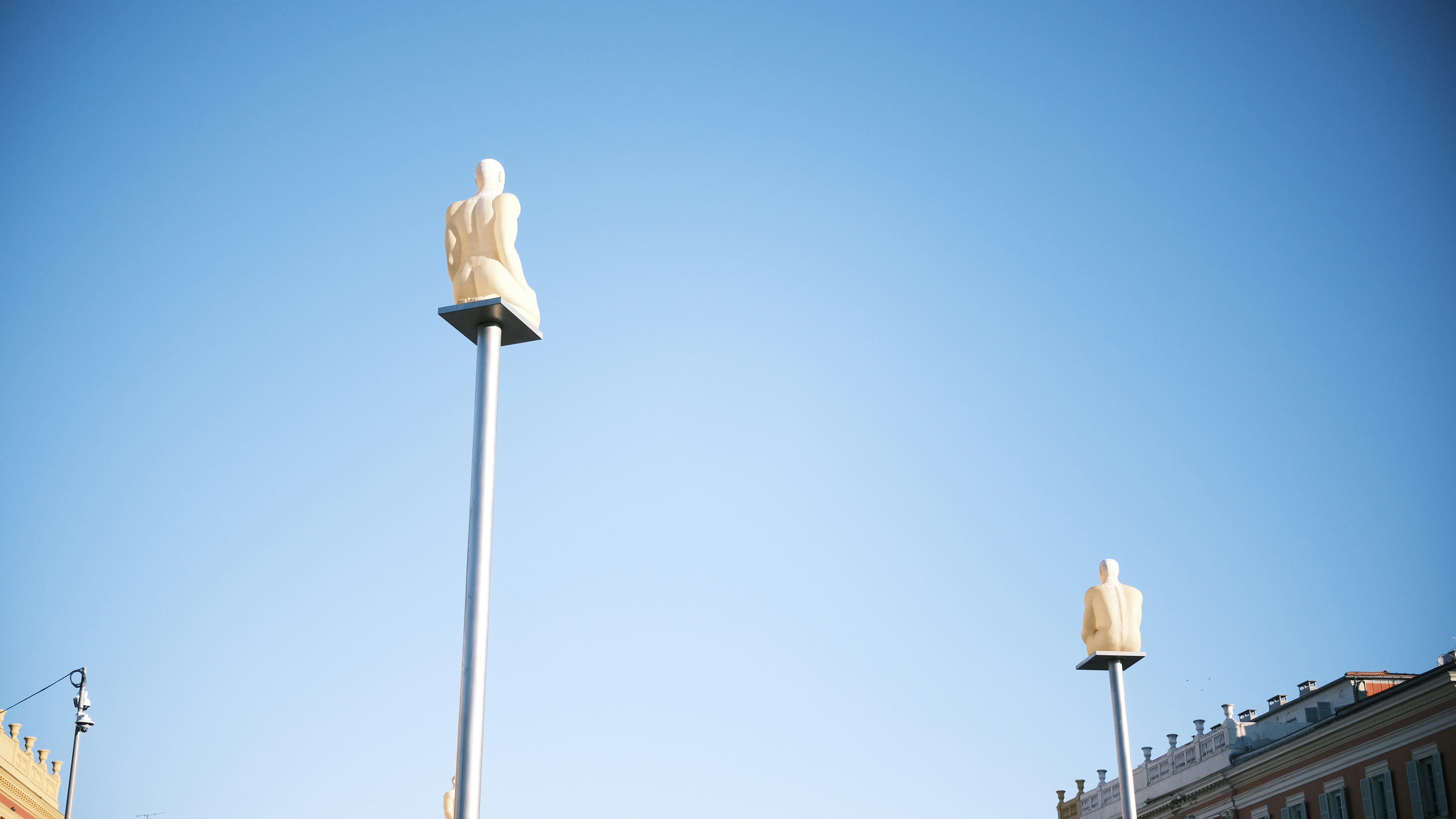 Two Skyward Hands on Slender Poles Against a Cerulean Sky