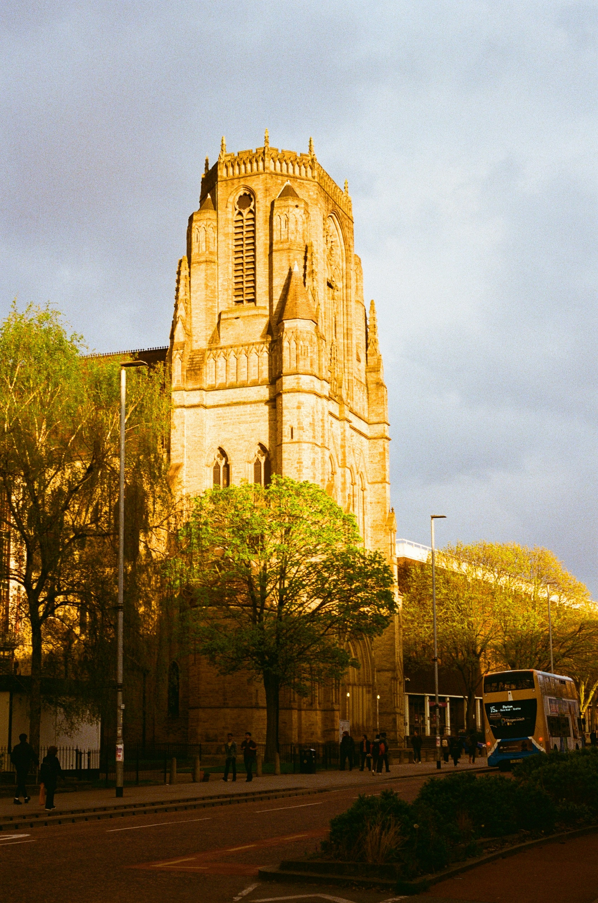 Sunlit Gothic Tower Rising Over a Busy Urban Street