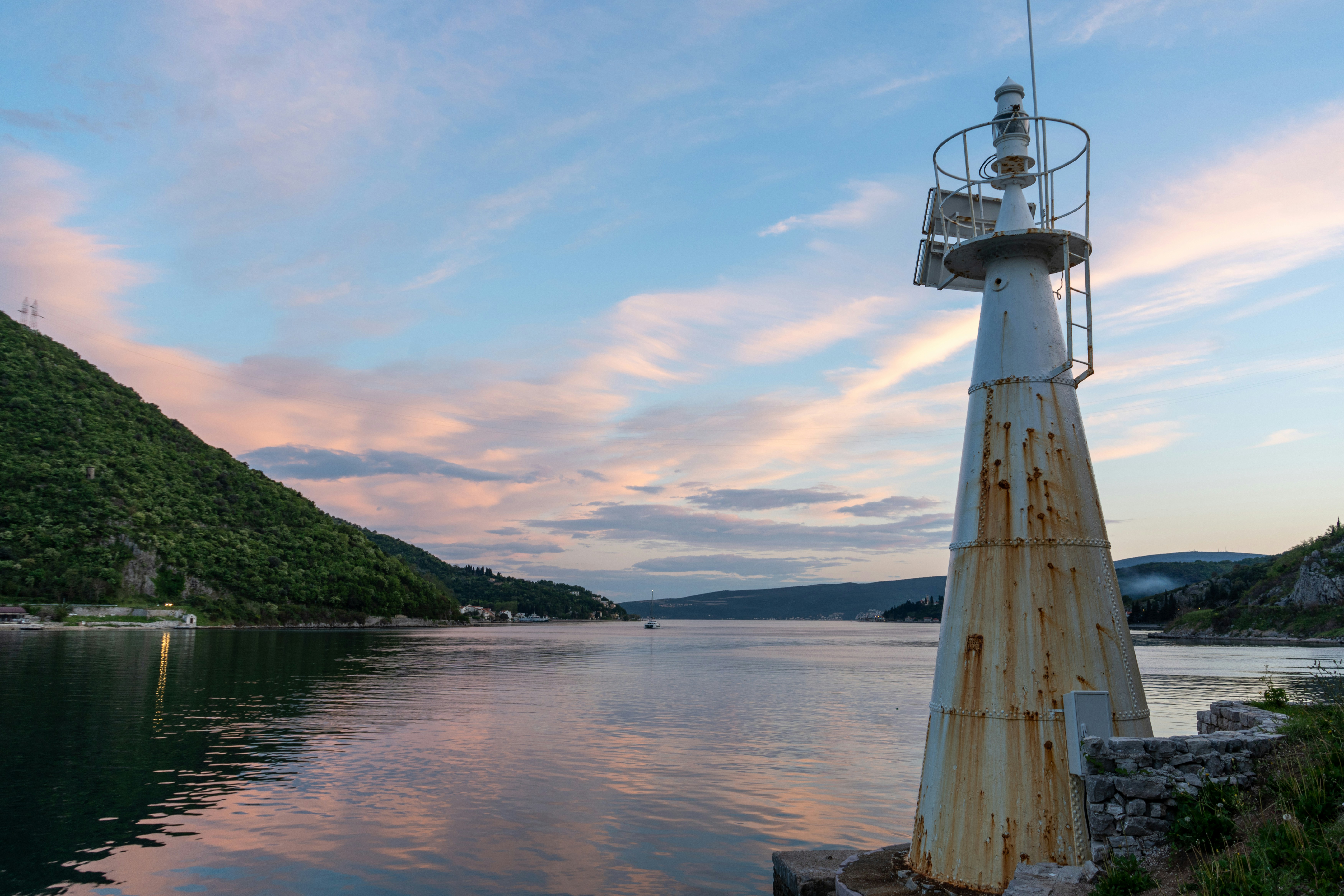 Rusting Sentinel at Dusk: A Harbor Lighthouse Guarding Quiet Waters