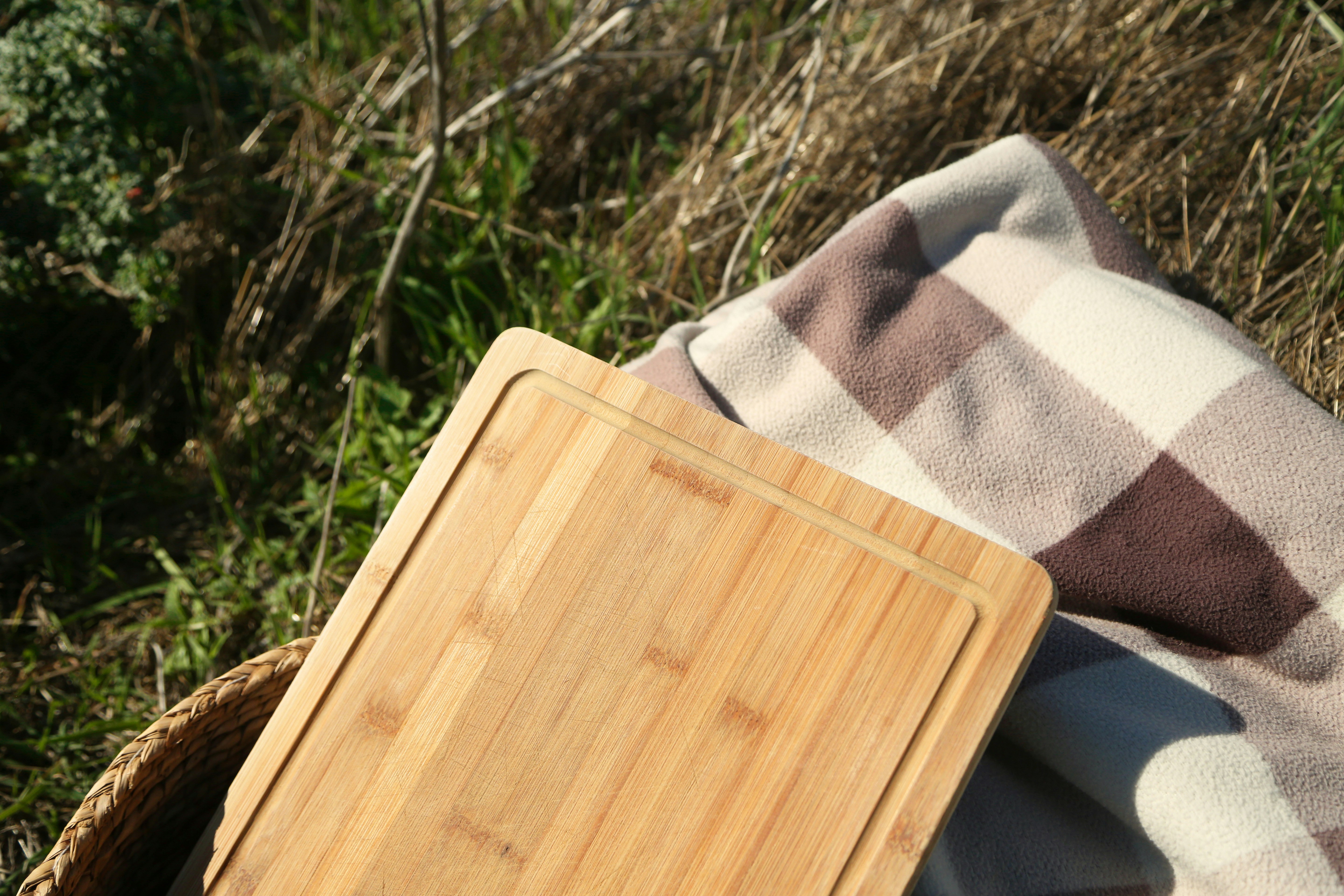 A wooden cutting board sitting on top of a blanket photo – Free Food ...