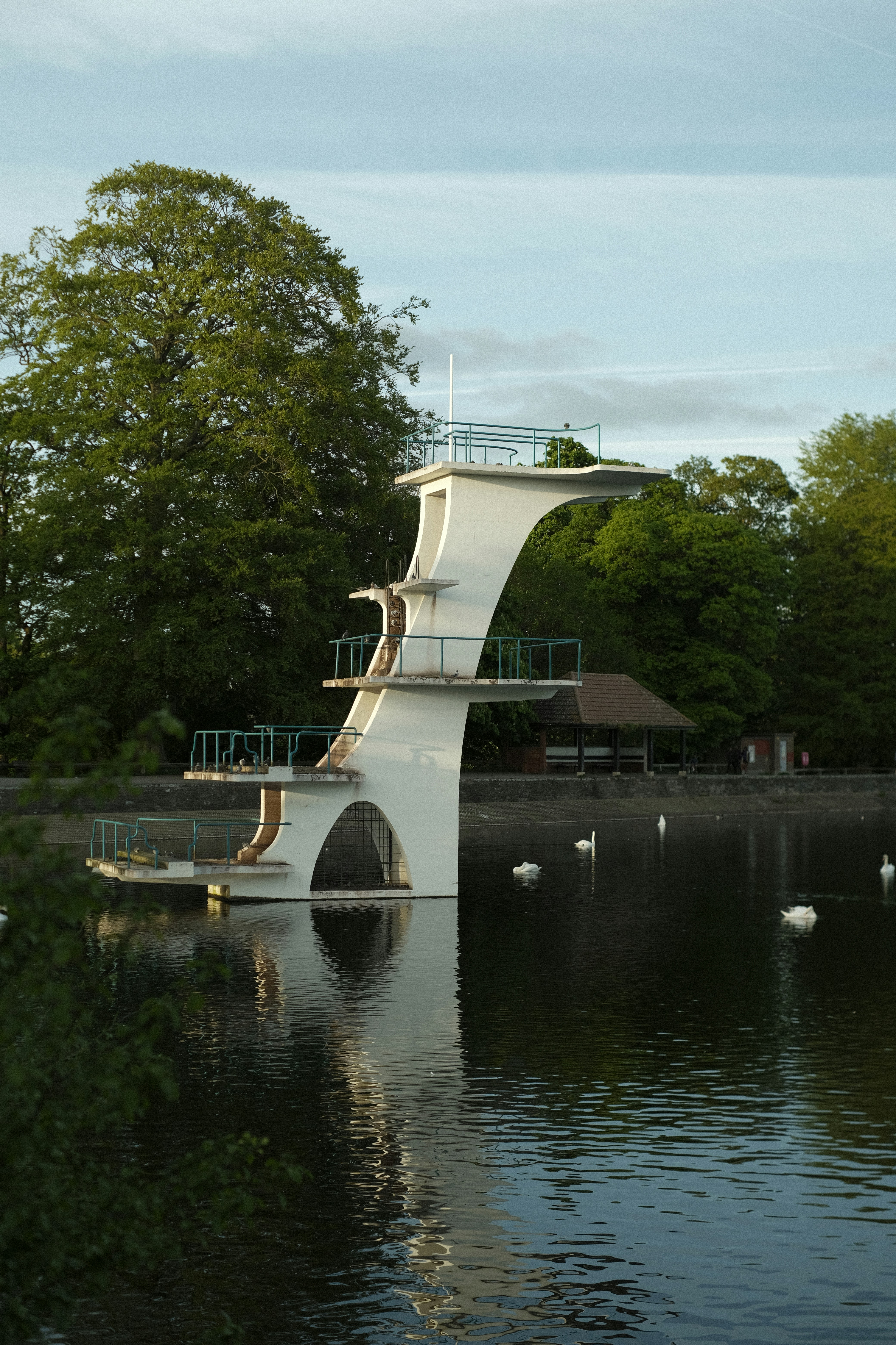Arching White Dive Tower Over a Tranquil Lake