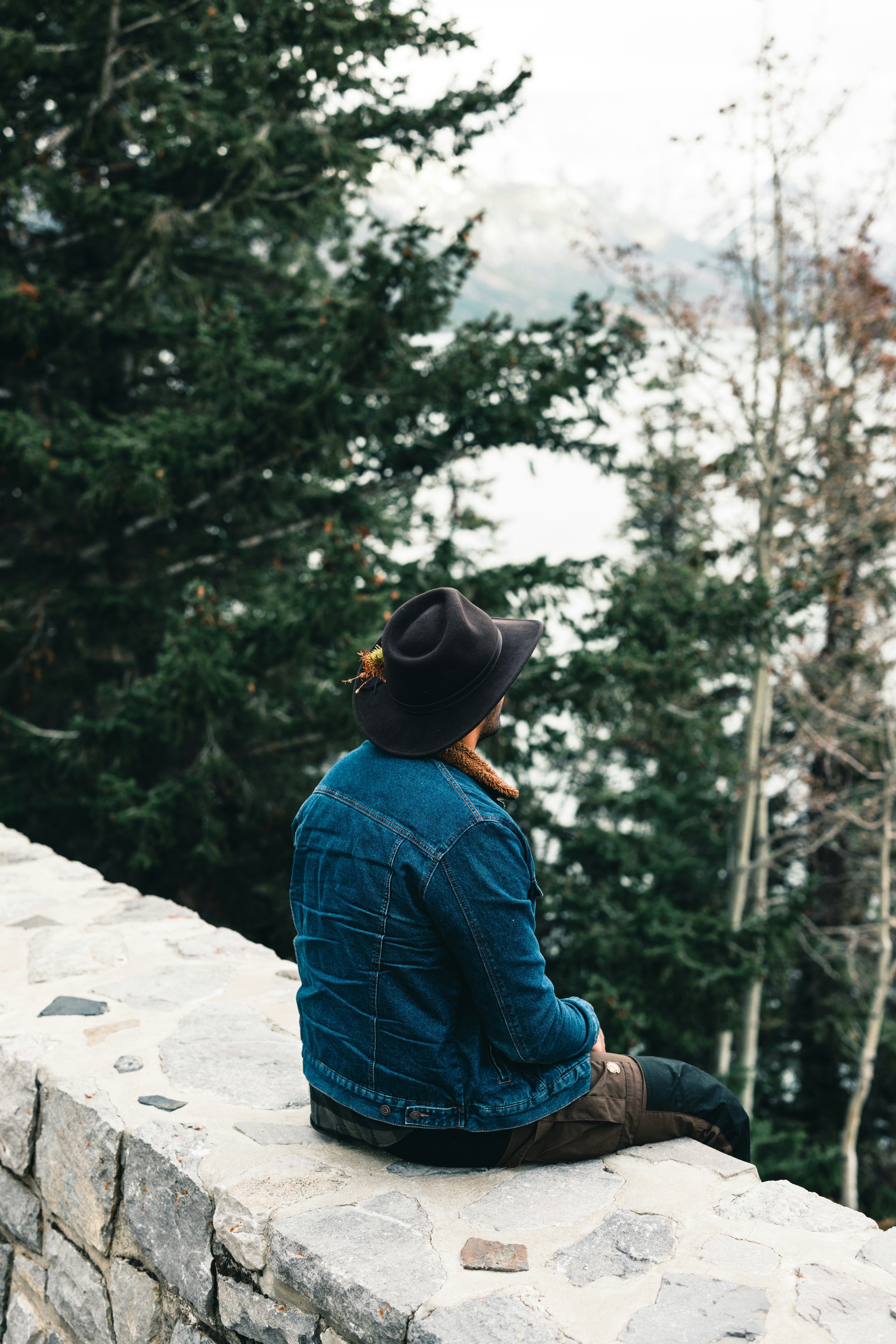 Une personne assise au sommet d’un mur de pierre photo – Image gratuite ...