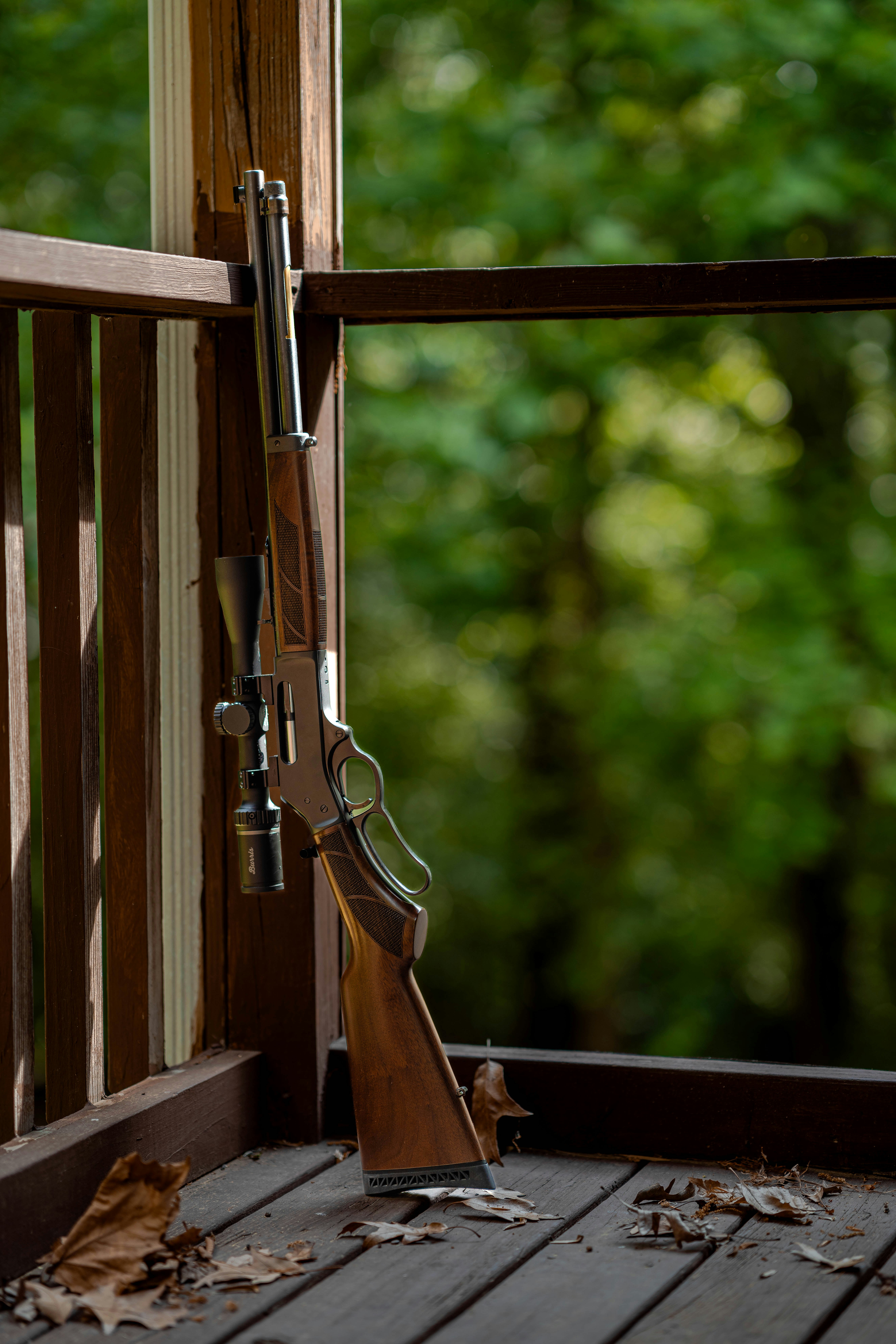 A rifle on a porch next to a window photo – Free Rifle Image on Unsplash