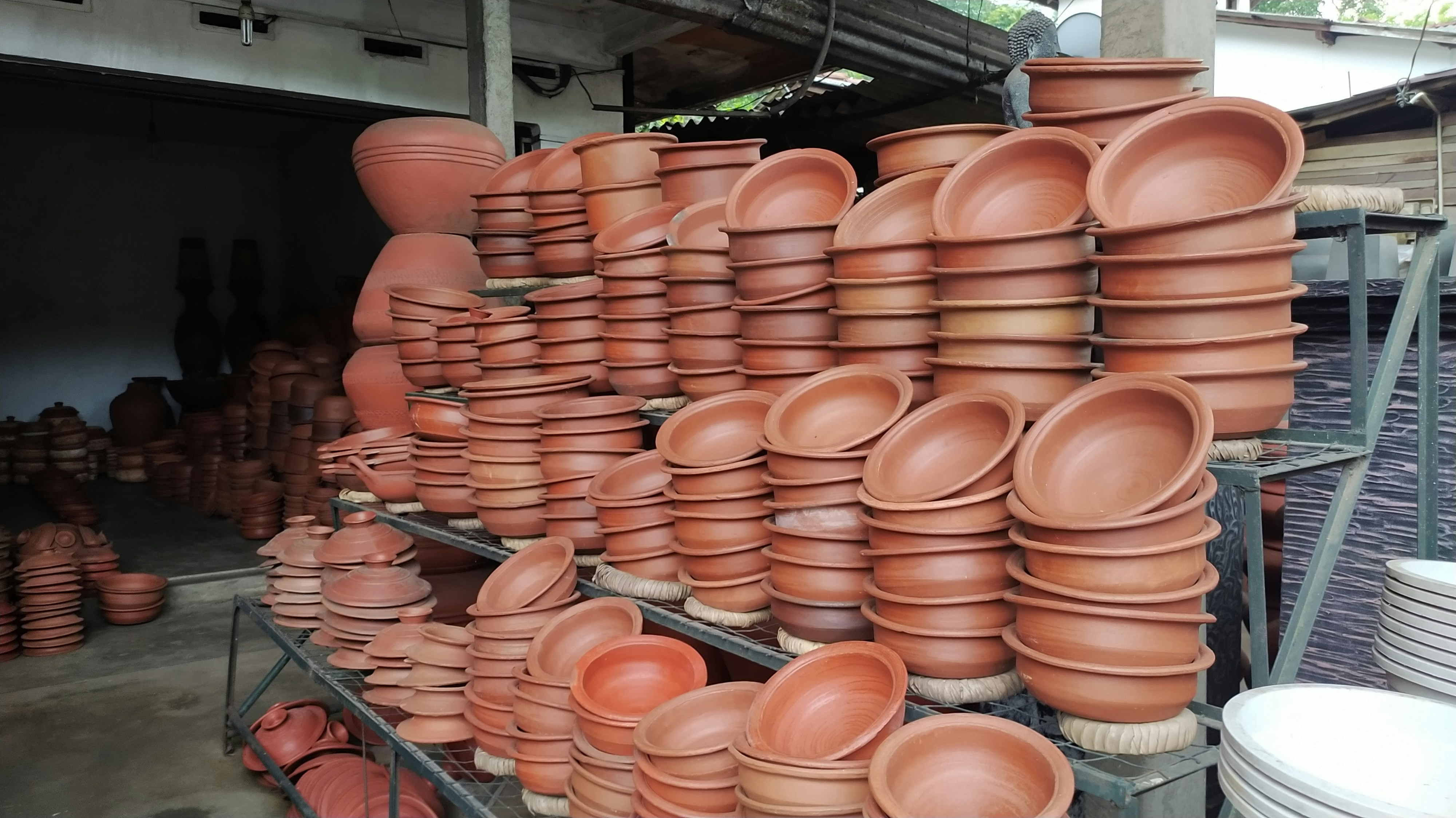 A bunch of clay pots are stacked on a rack photo – Free Art Image on ...