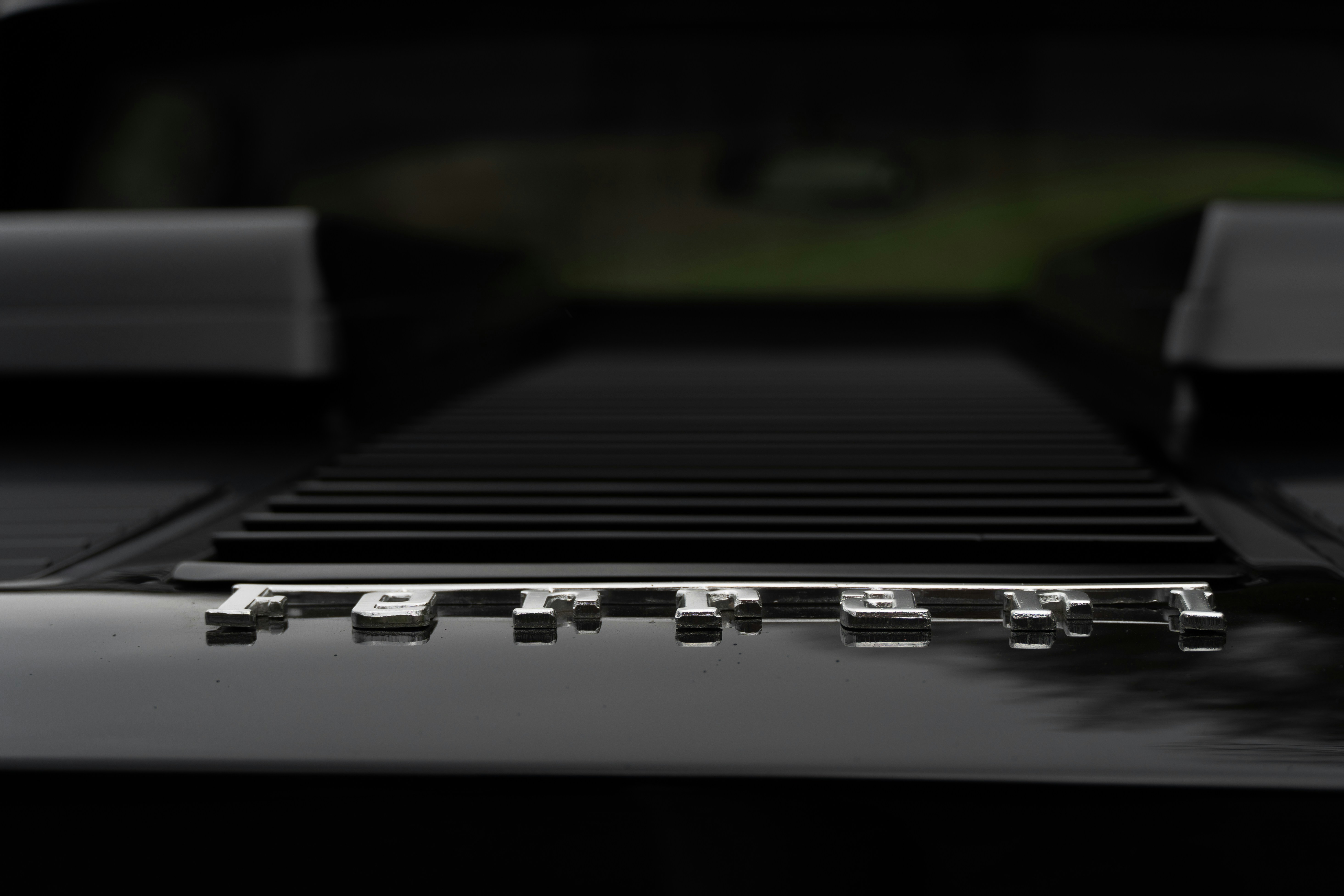 Chrome Letters on a Gleaming Hood Reaching Toward a Darkened Road
