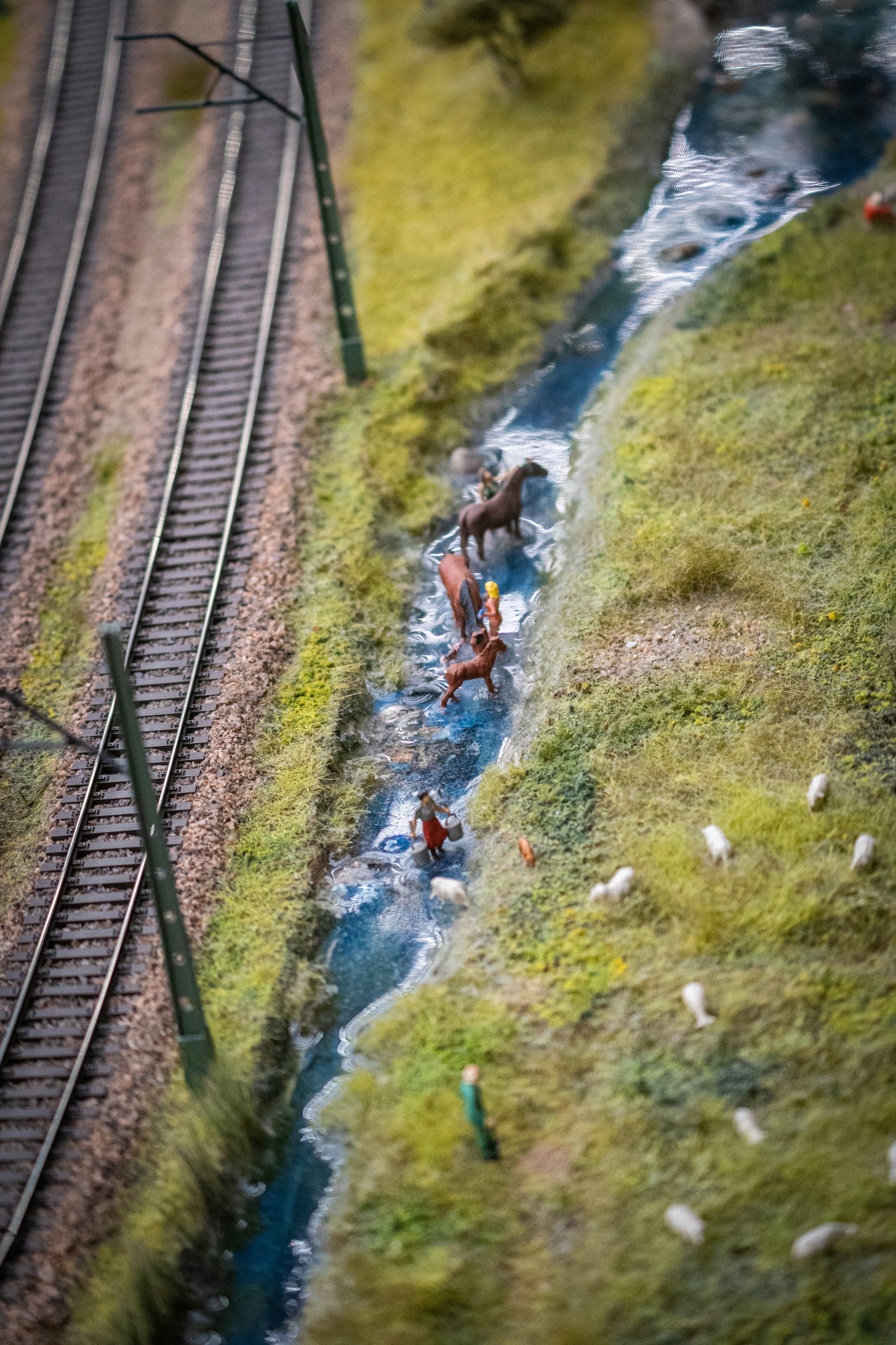 Miniature Trainline Drama: People and Horses in a Narrow Riverbank