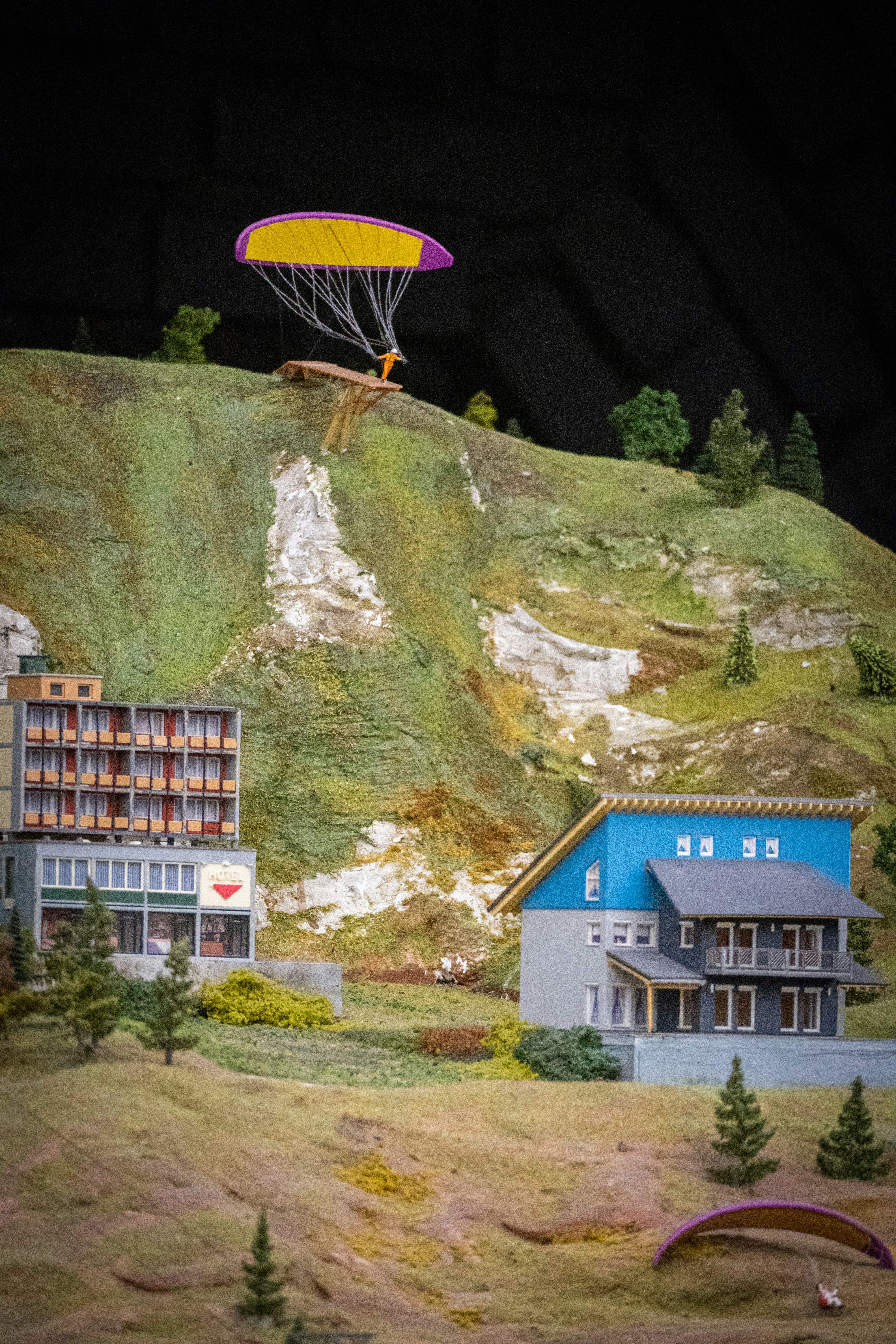 A model of a building with a parachute flying over it photo – Free ...