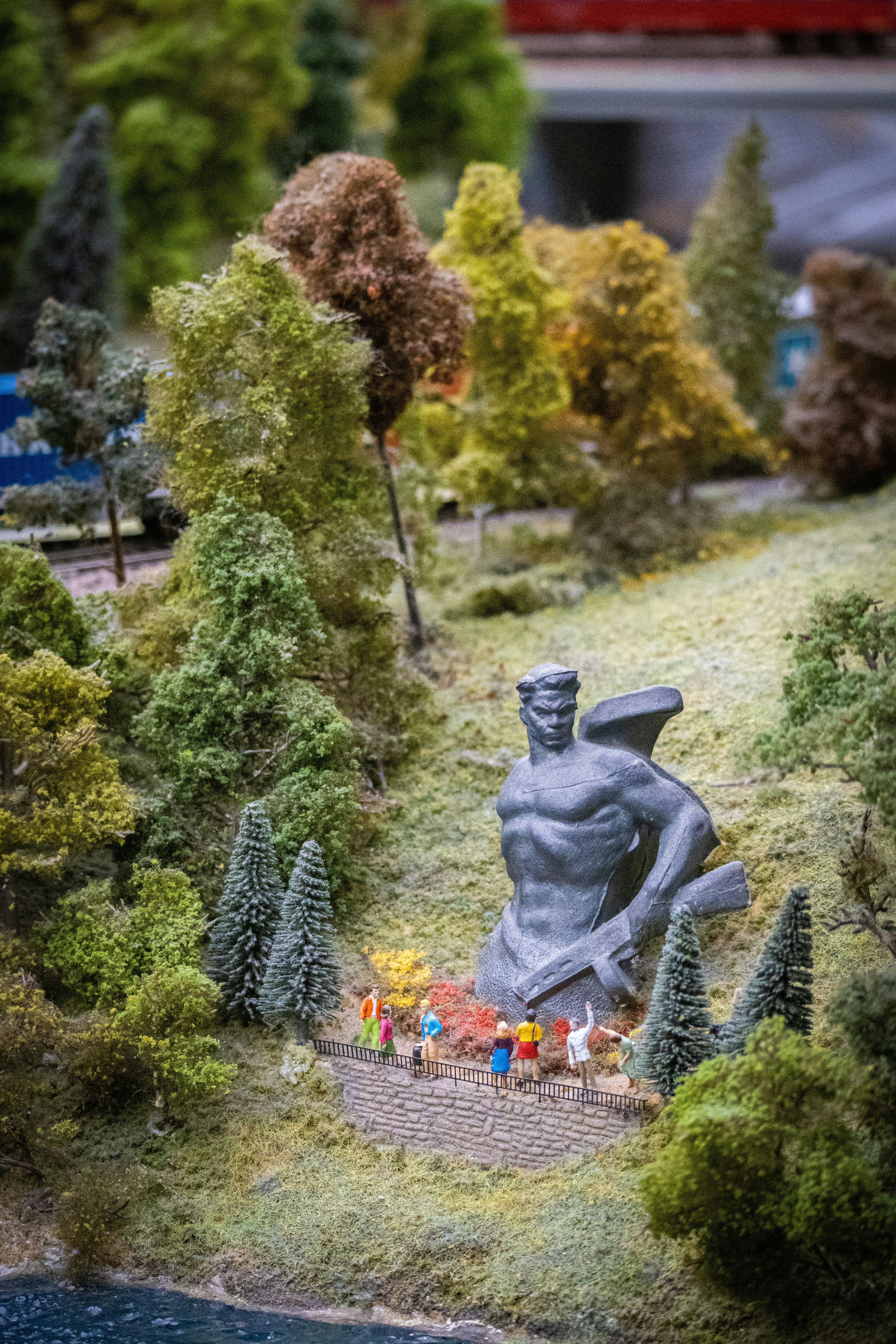 Giant Sentinel Over a Minuscule Riverside Throng