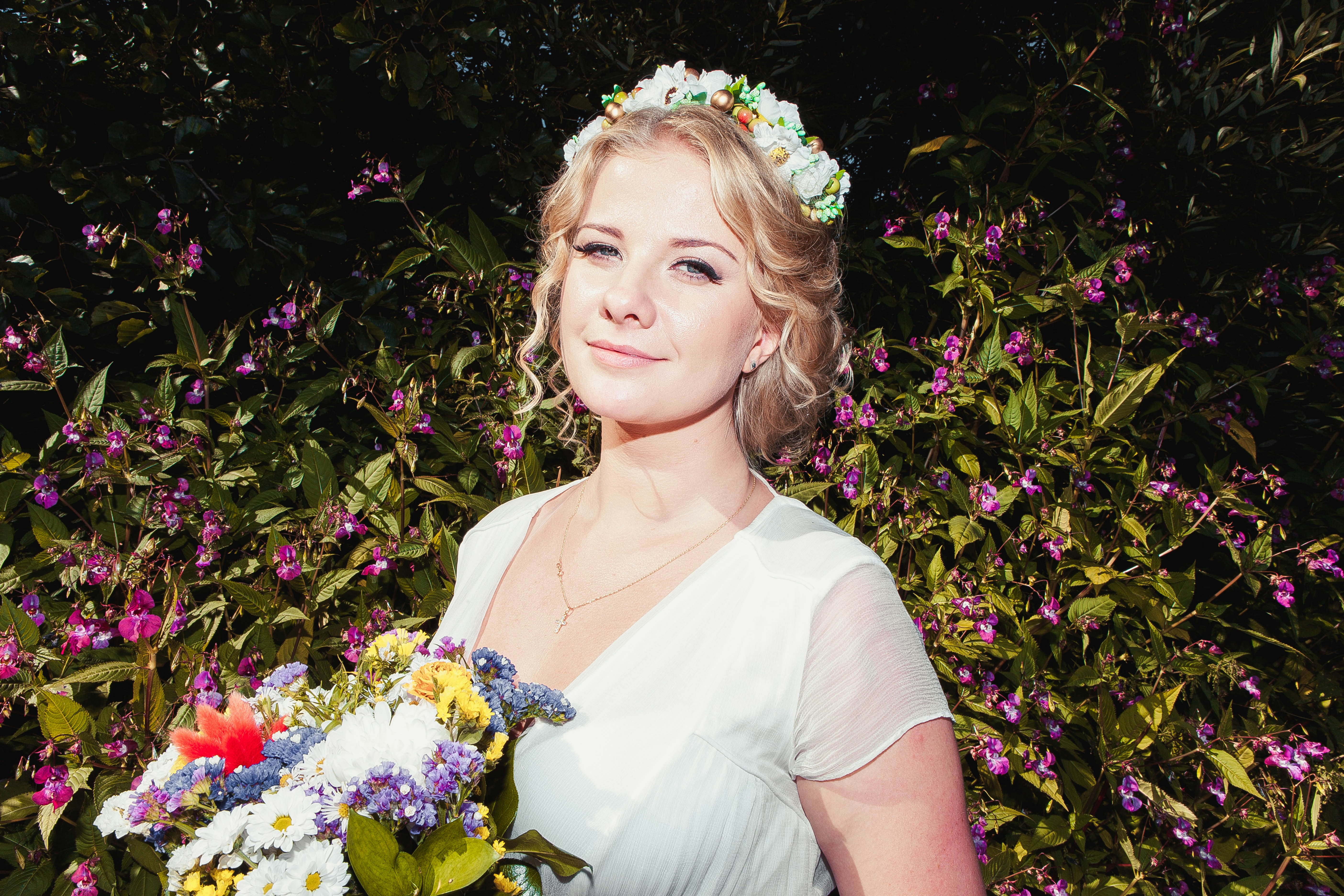 Sunlit Bride with a Crown of Wildflowers in a Quiet Garden