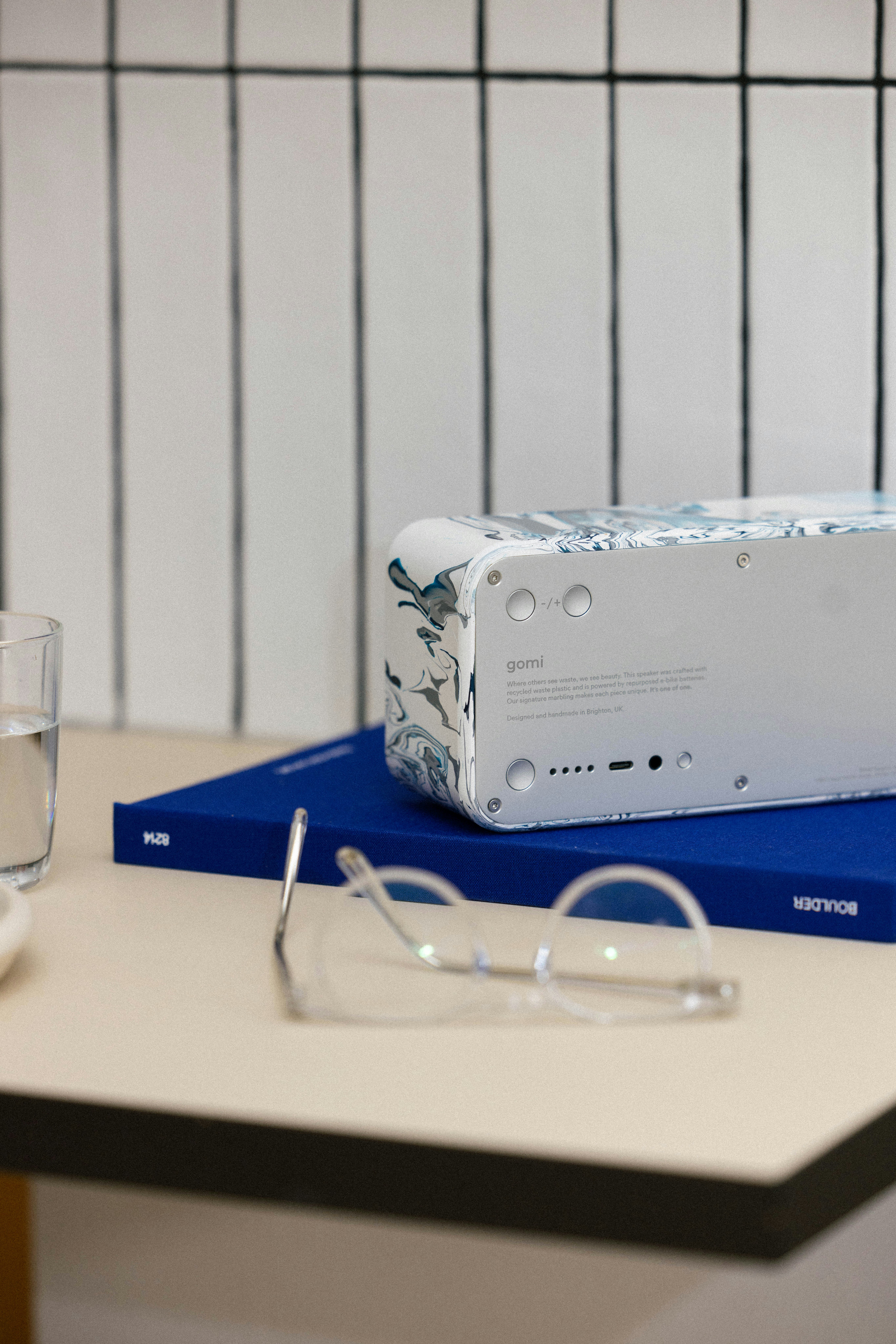 Floral-patterned gadget perched on a cobalt book in a quiet desk still life