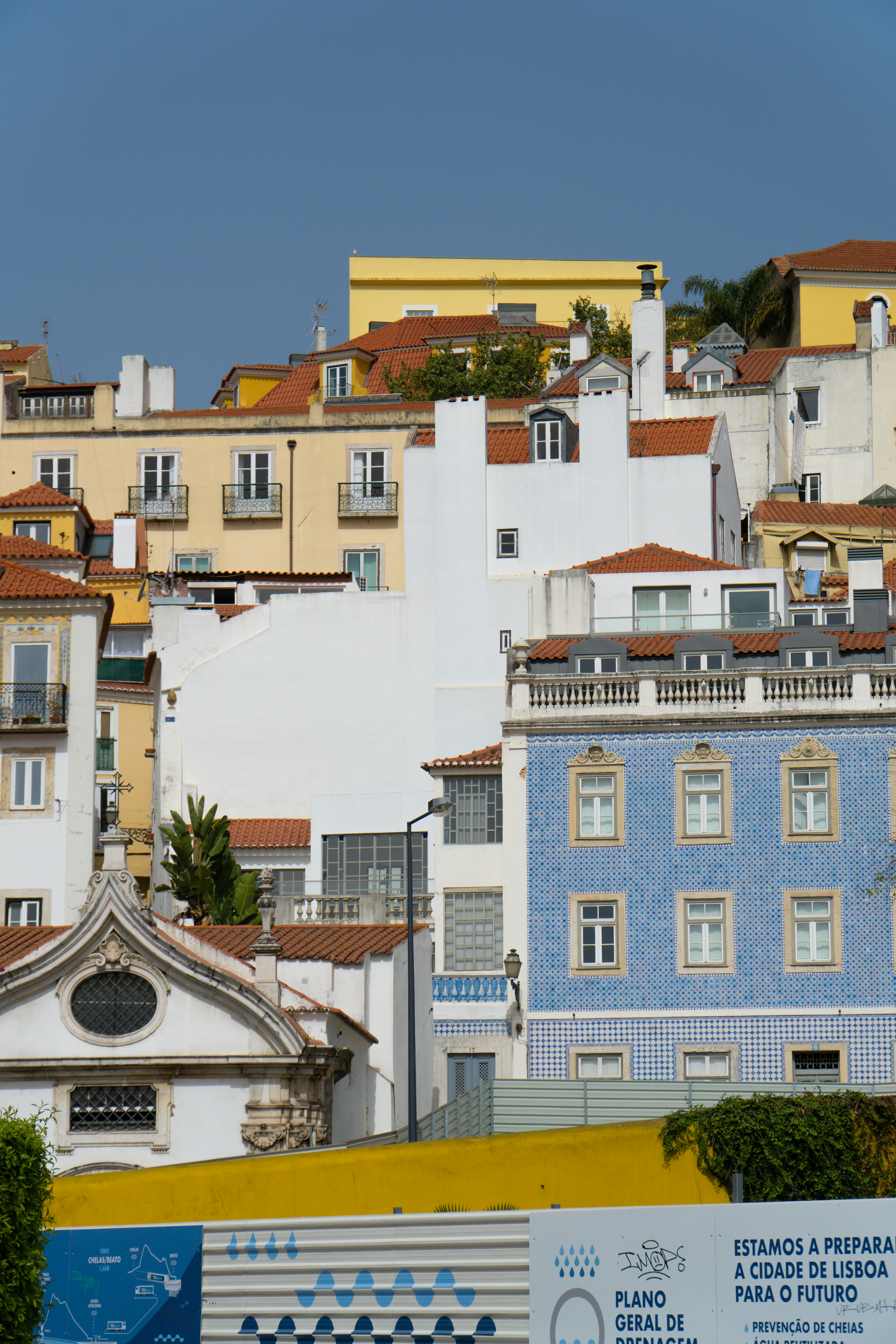 Colorful buildings stacked harmoniously against a clear blue sky, showcasing Lisbon's unique architectural style and vibrant atmosphere.