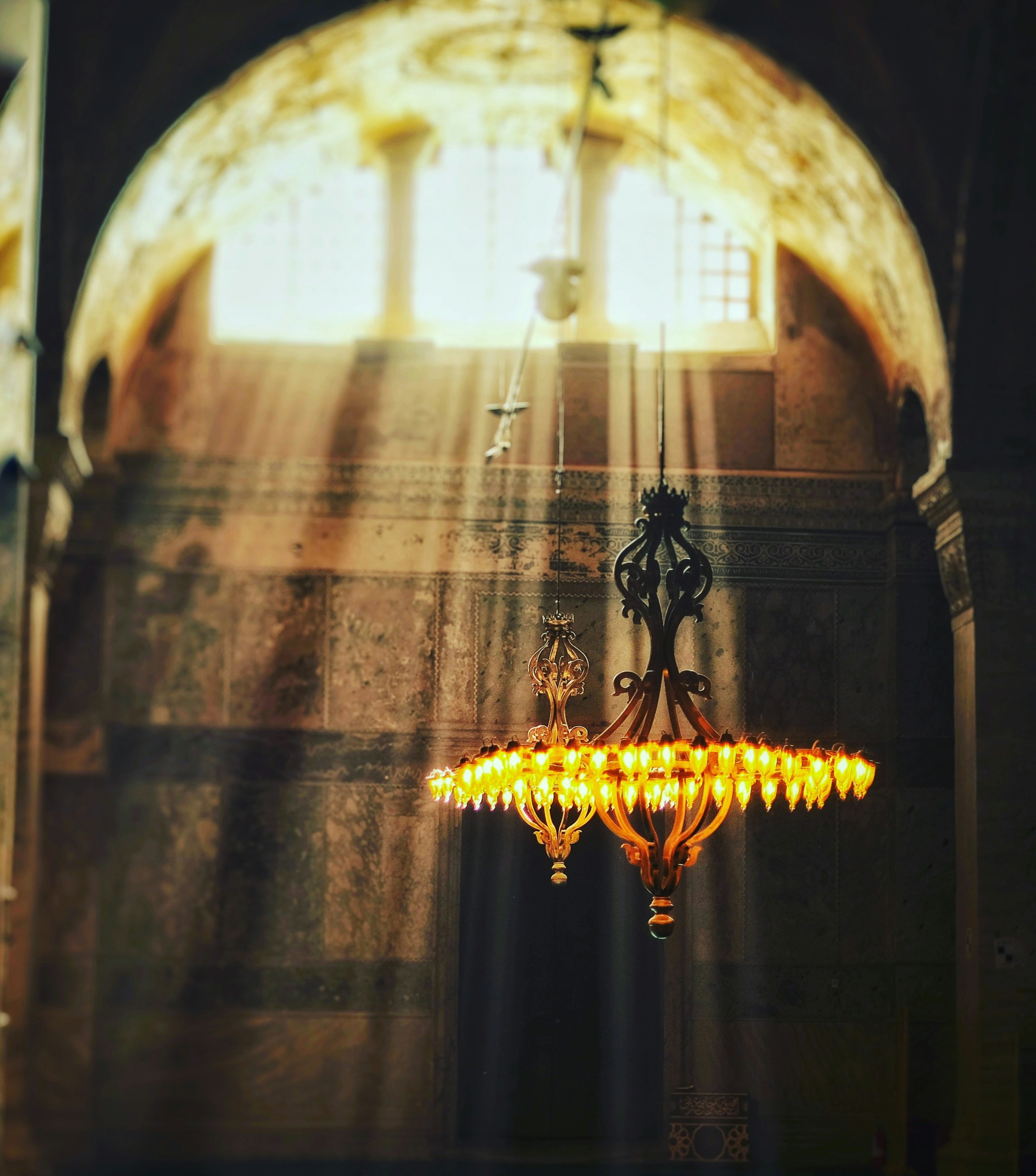 Amber Halo: A Central Chandelier Refracted Through Historic Archways