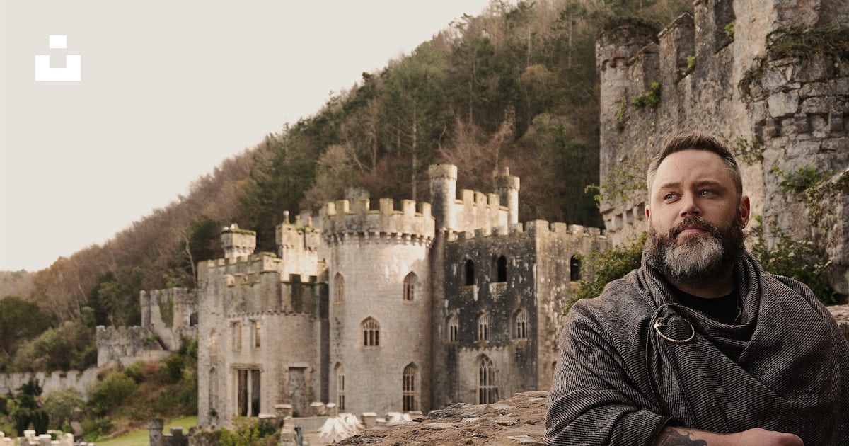 Un Homme Debout à Côté Dun Mur De Pierre Près Dun Château Photo